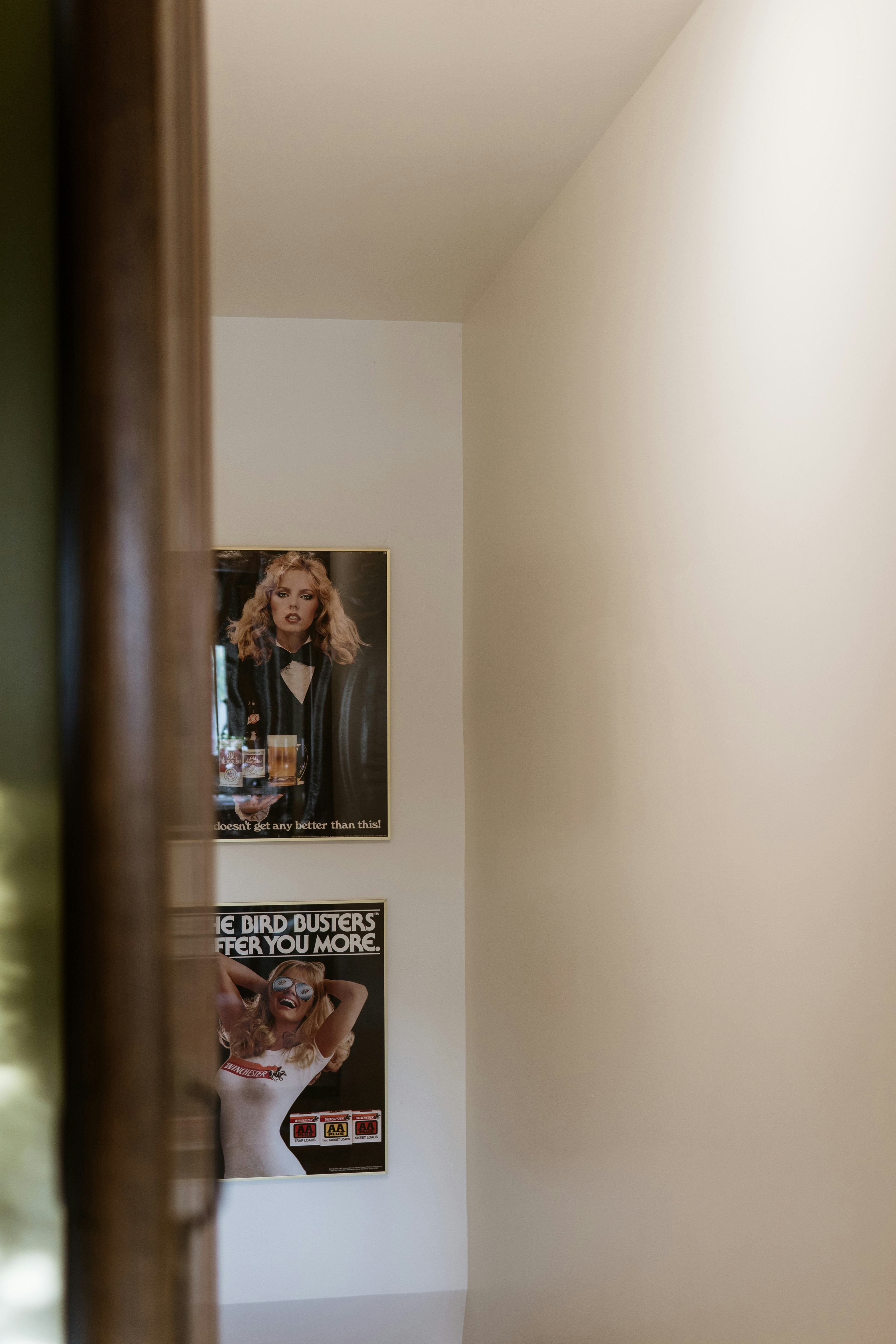 A hallway with posters on the wall and a wooden door photo – Free ...