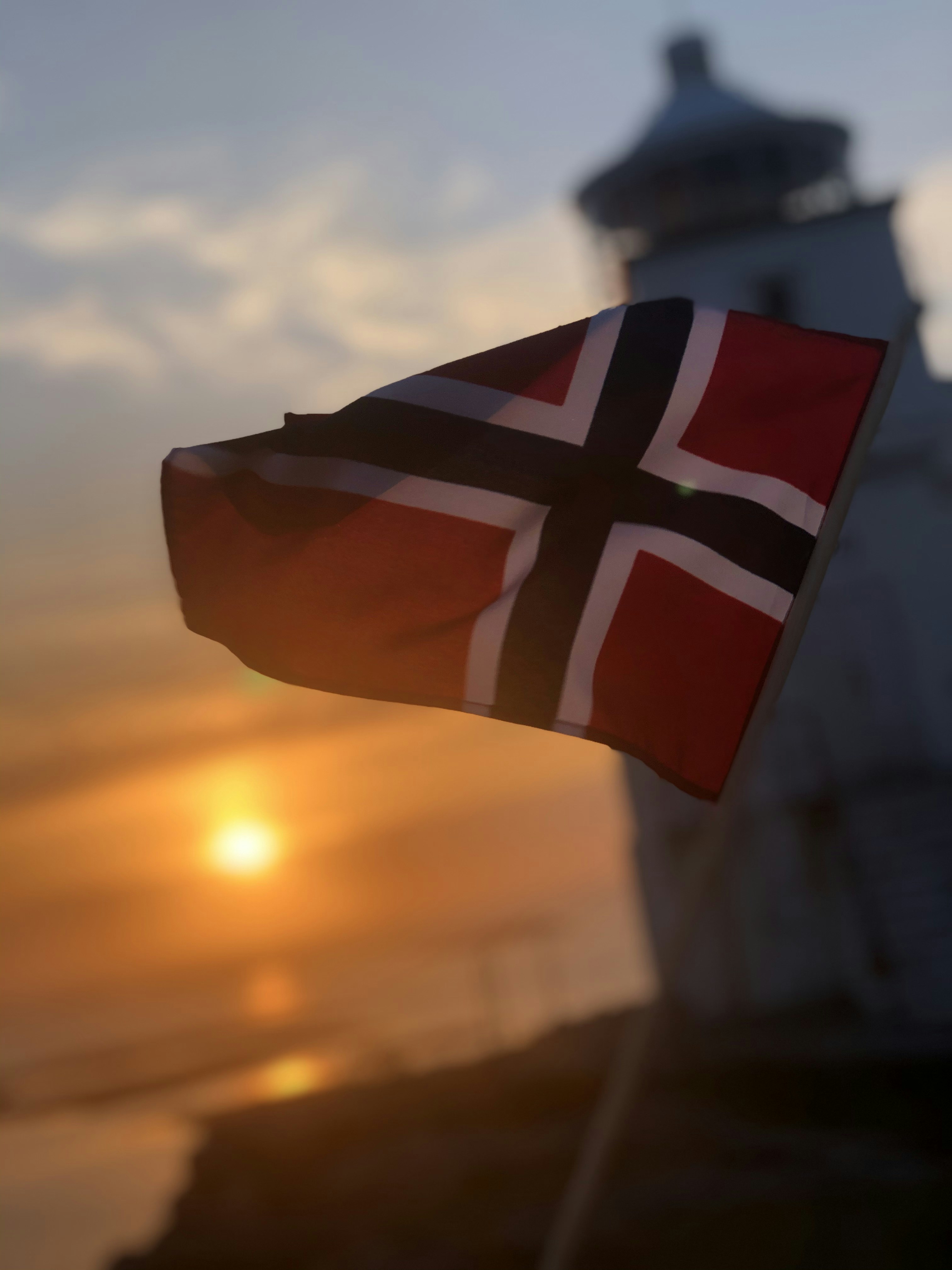 Norwegian Flag at Golden Hour: A Seaside Moment in Soft Evening Light