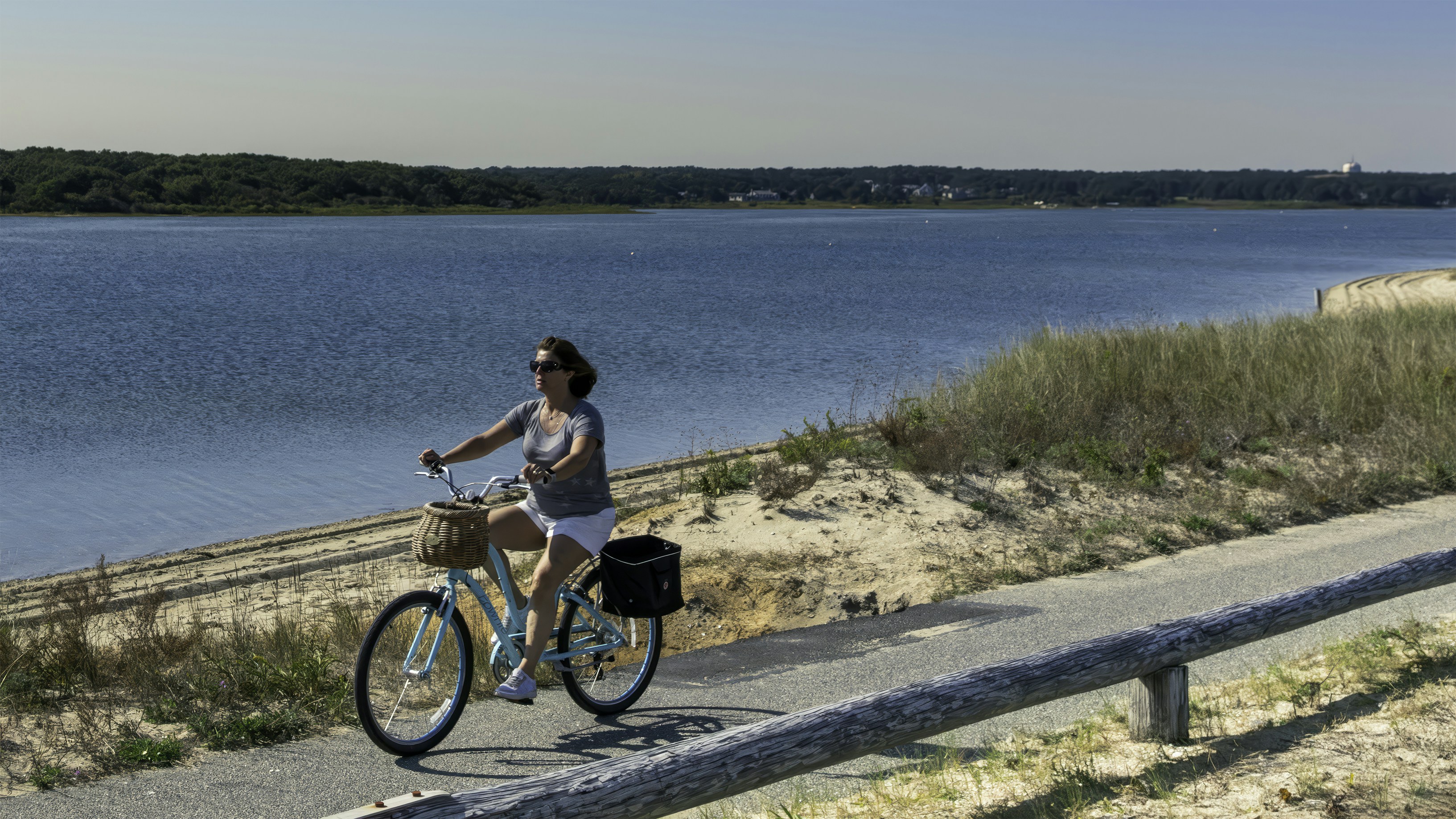 Lakeside Glide: A lone cyclist on a sunlit lakeshore trail
