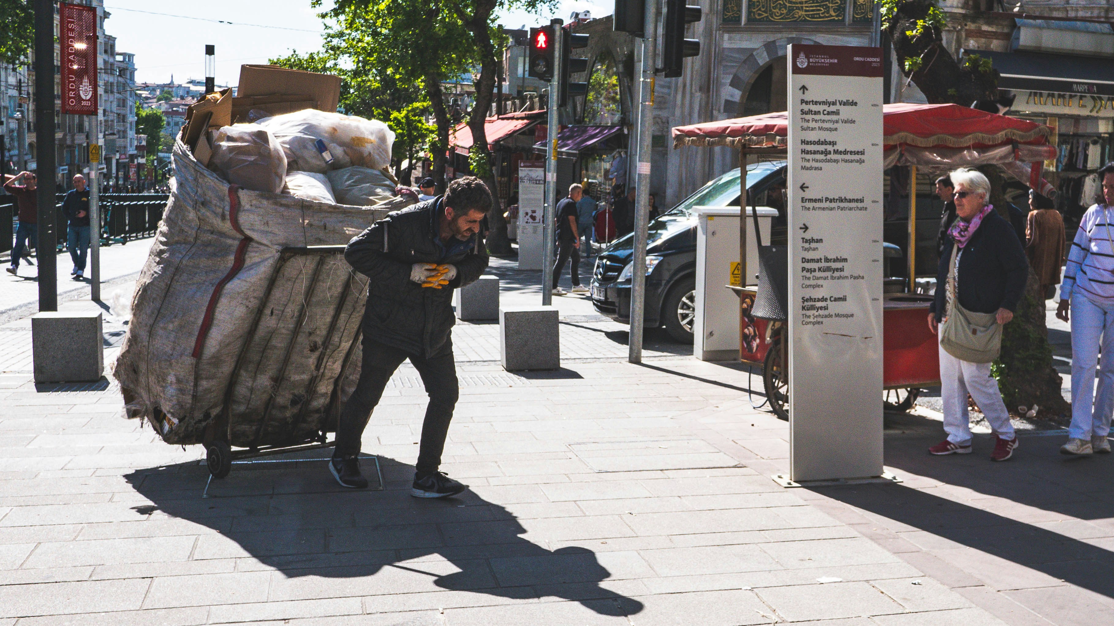 A man pushing a cart full of items down a street photo – Free İstanbul ...