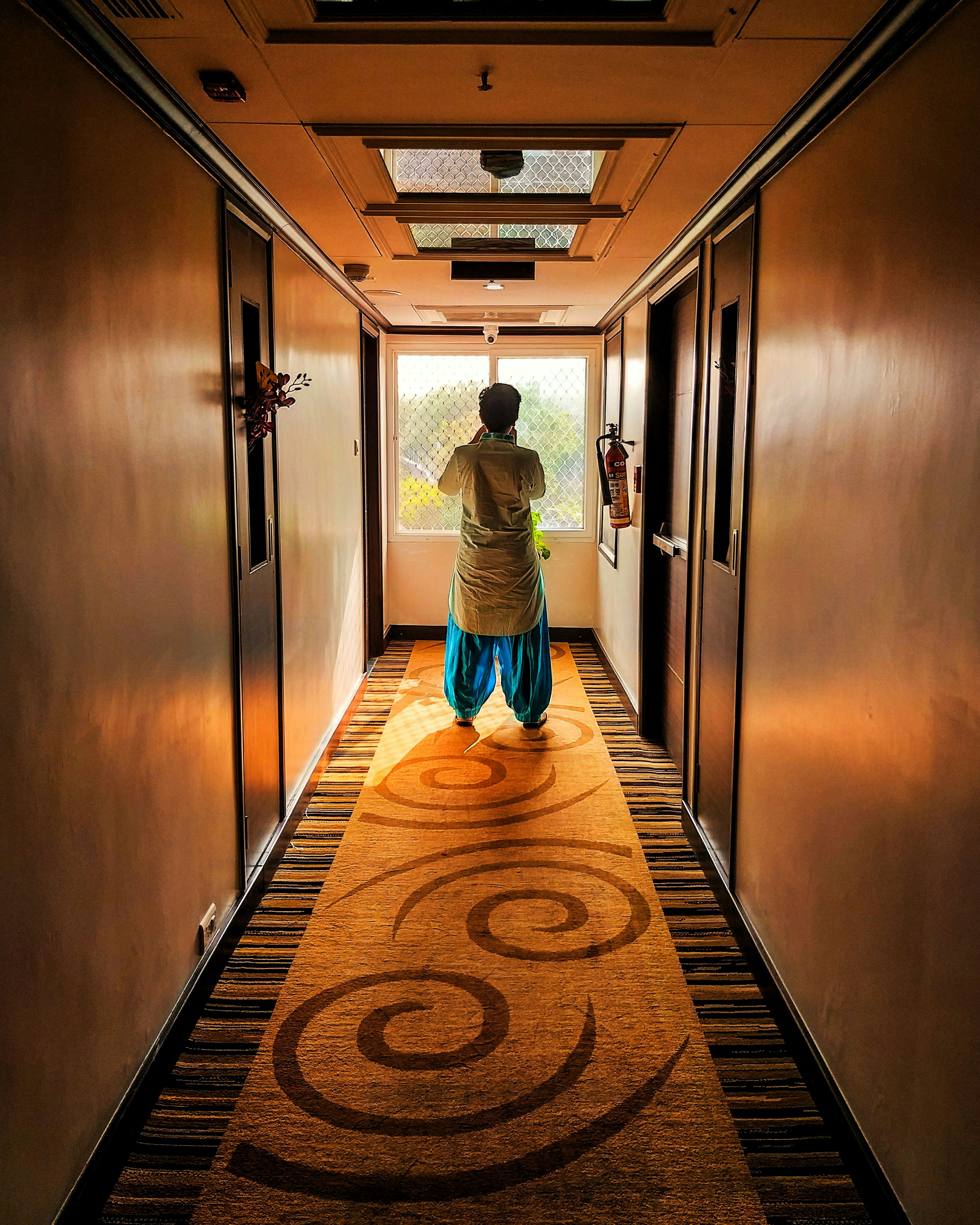 Backlit Silent Corridor: A Traveler in the Glow