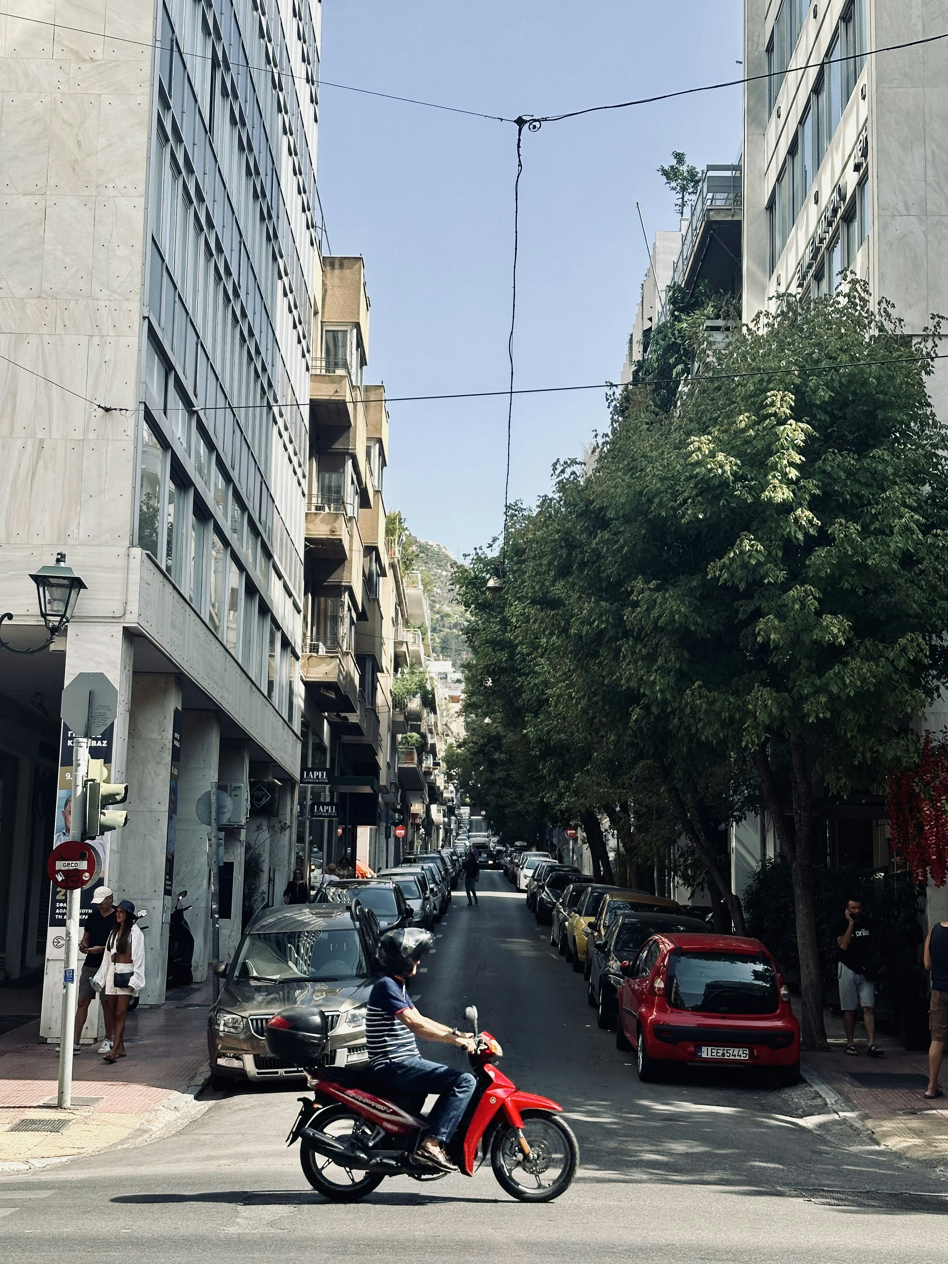 Red Moto at a Sunlit Urban Avenue