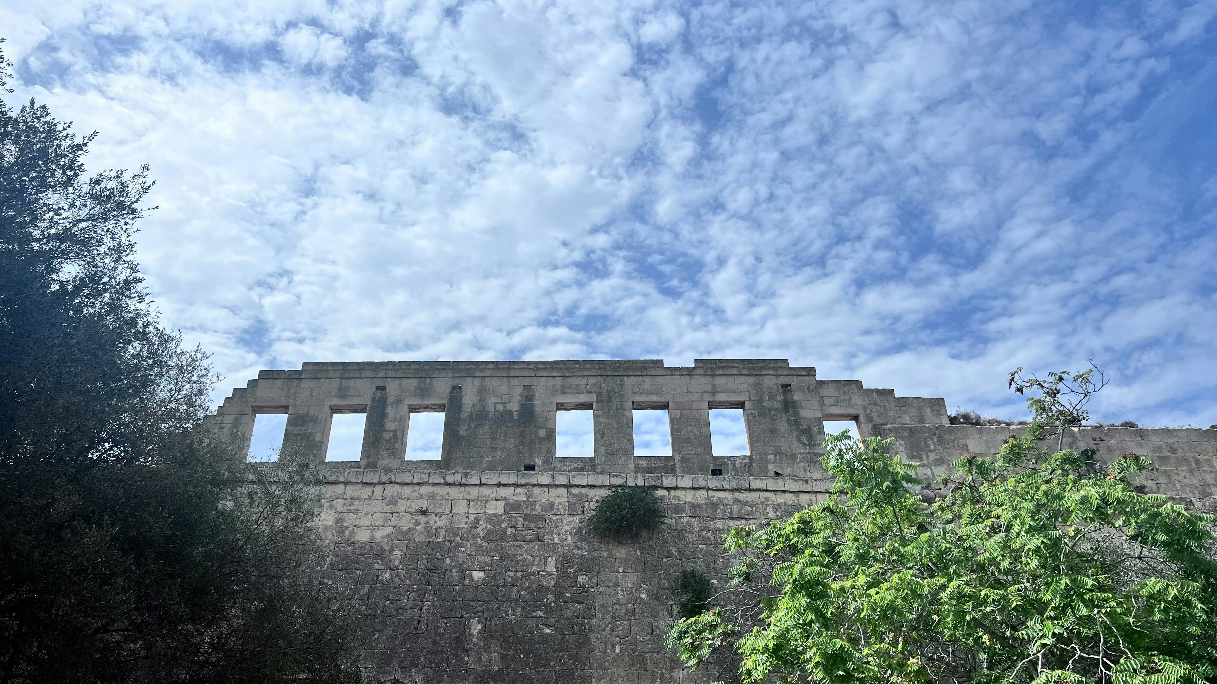 Ruin's Skyline: Weathered Stone Framed by Verdant Edges Under a Cerulean Sky