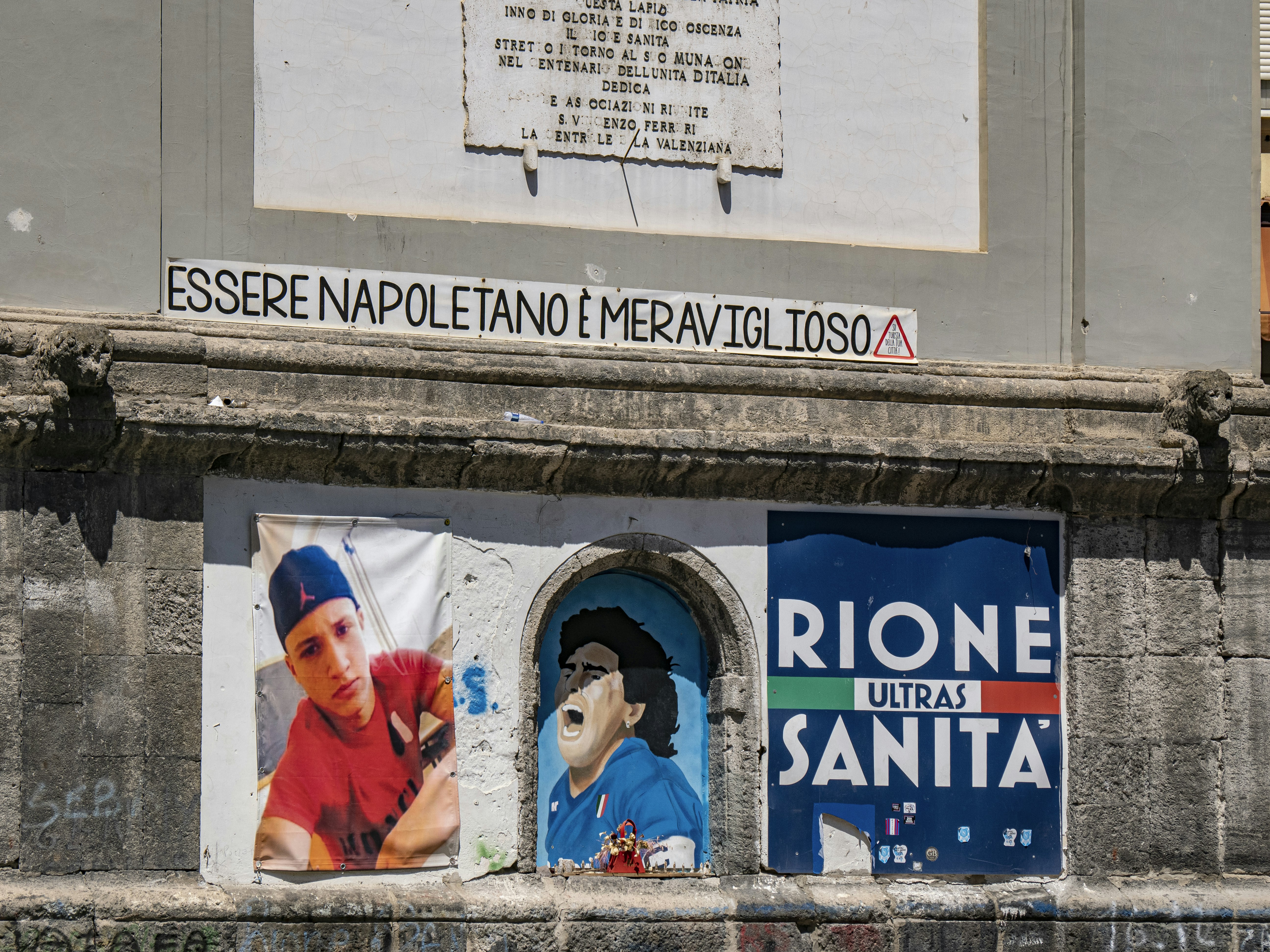 A building with a bunch of posters on the side of it photo – Free Woman ...