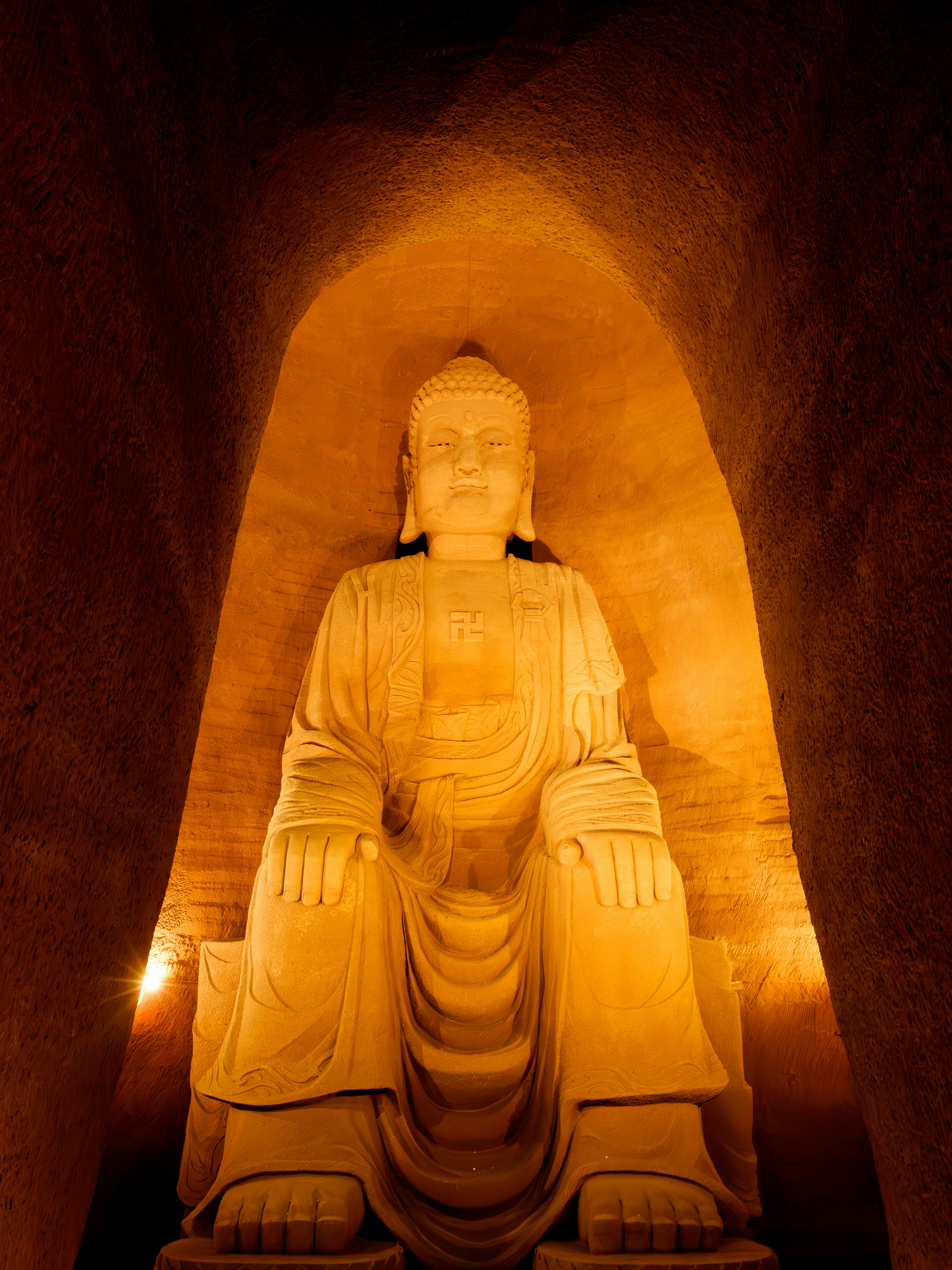 A large buddha statue sitting inside of a tunnel photo – Free China ...