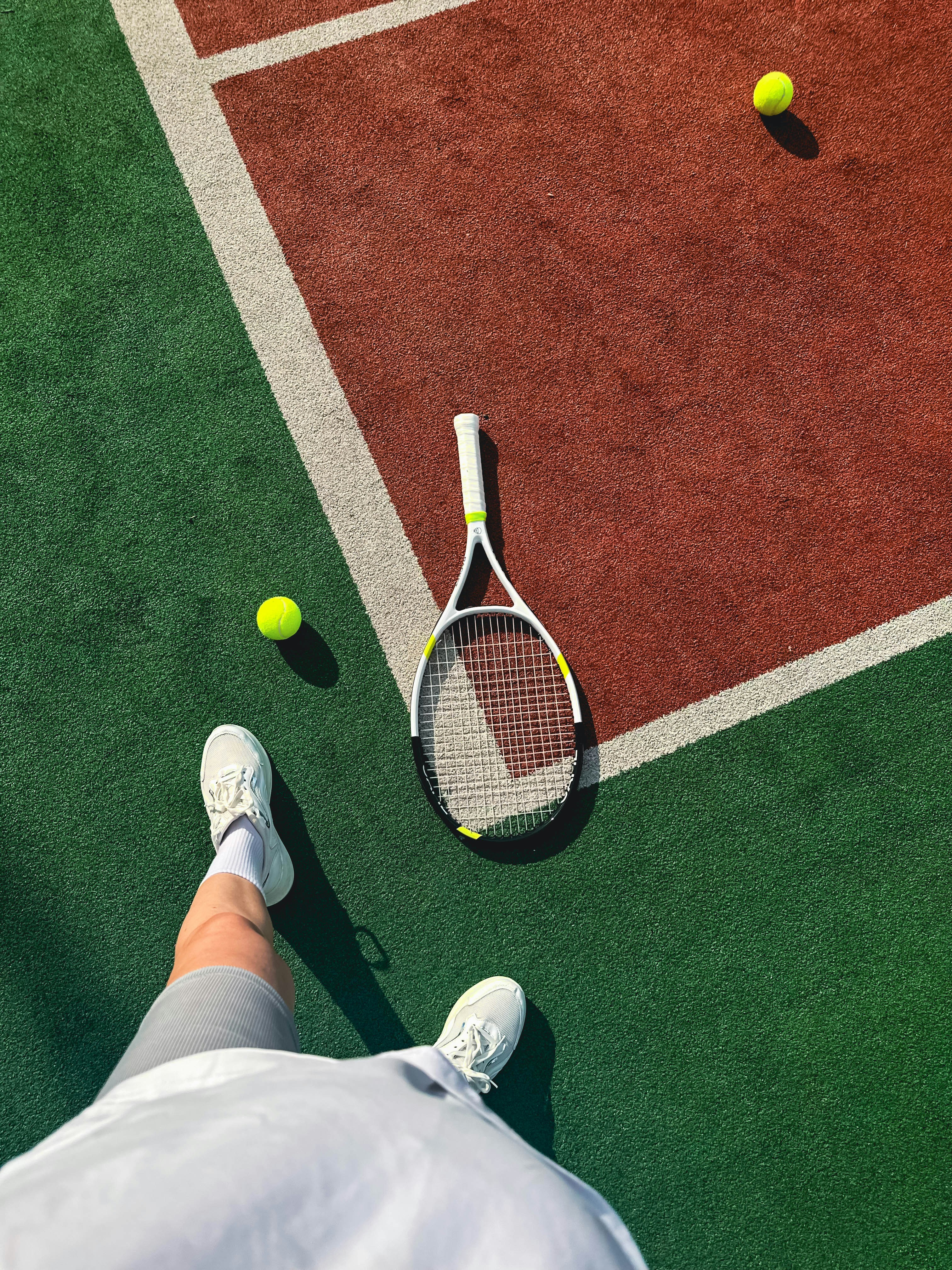 A person standing on a tennis court holding a racquet photo – Free ...