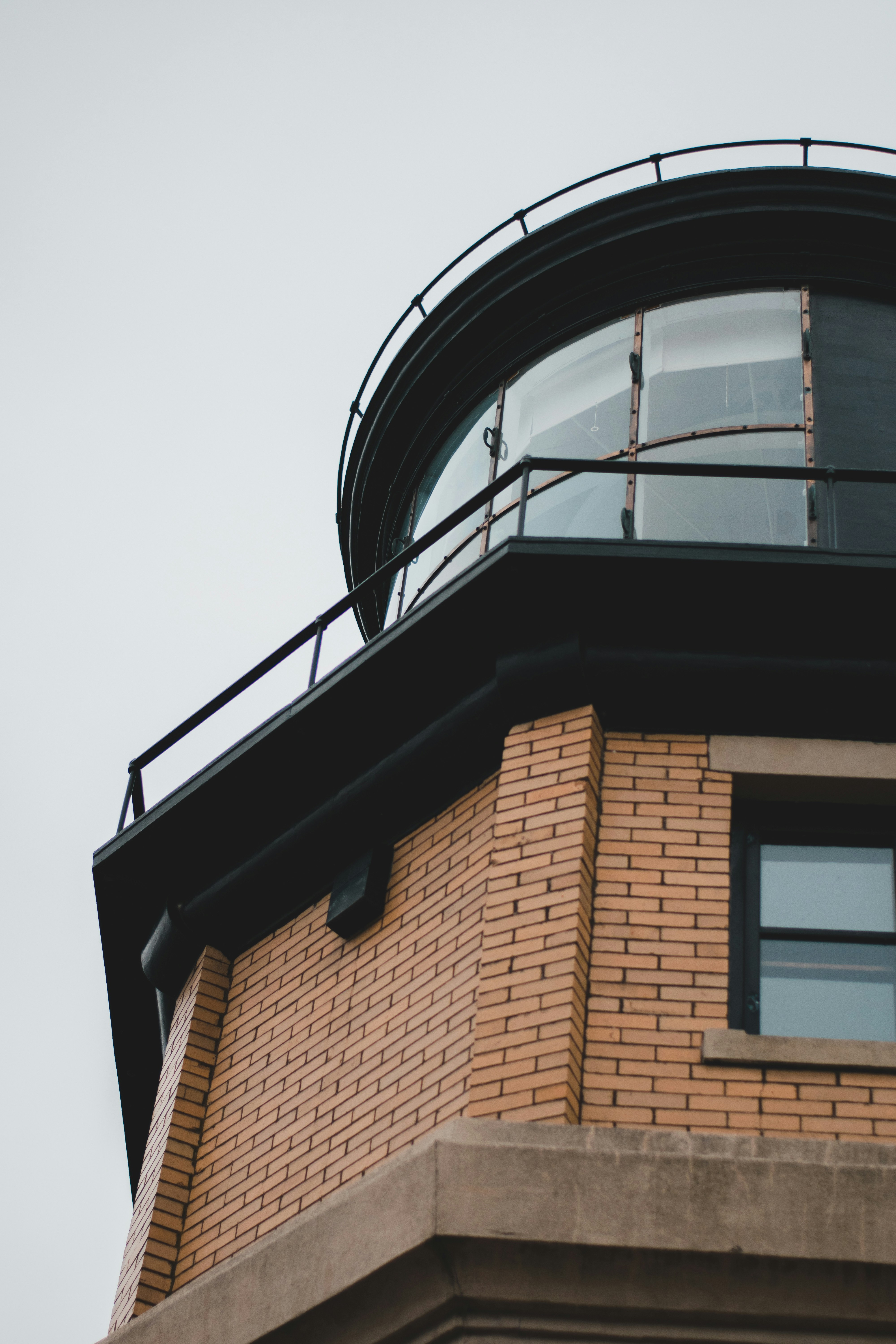 Rooftop Lantern: A Circular Glass Pavilion Above Brick Corner Rails