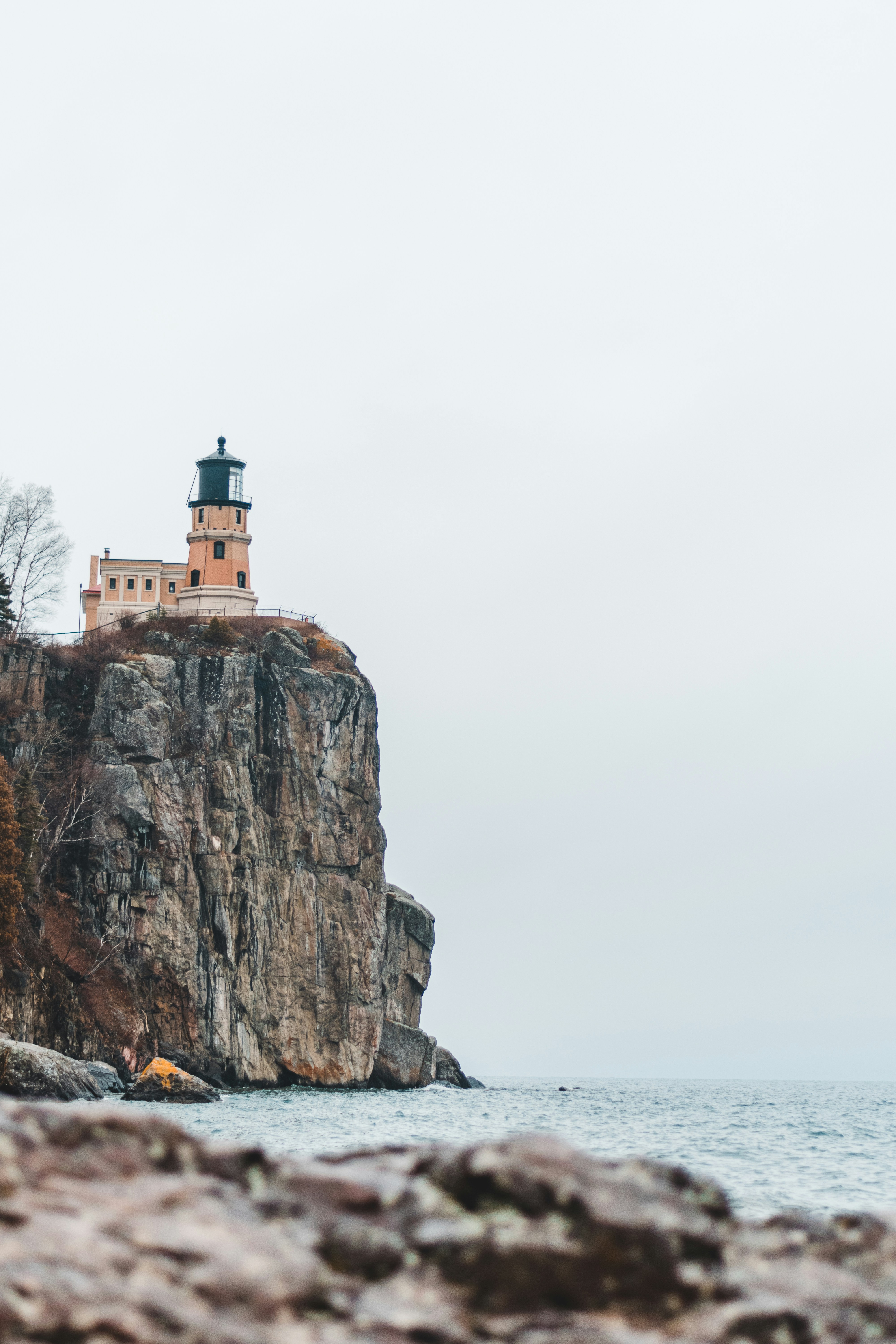 A lighthouse on top of a cliff near the ocean photo – Free Split rock ...