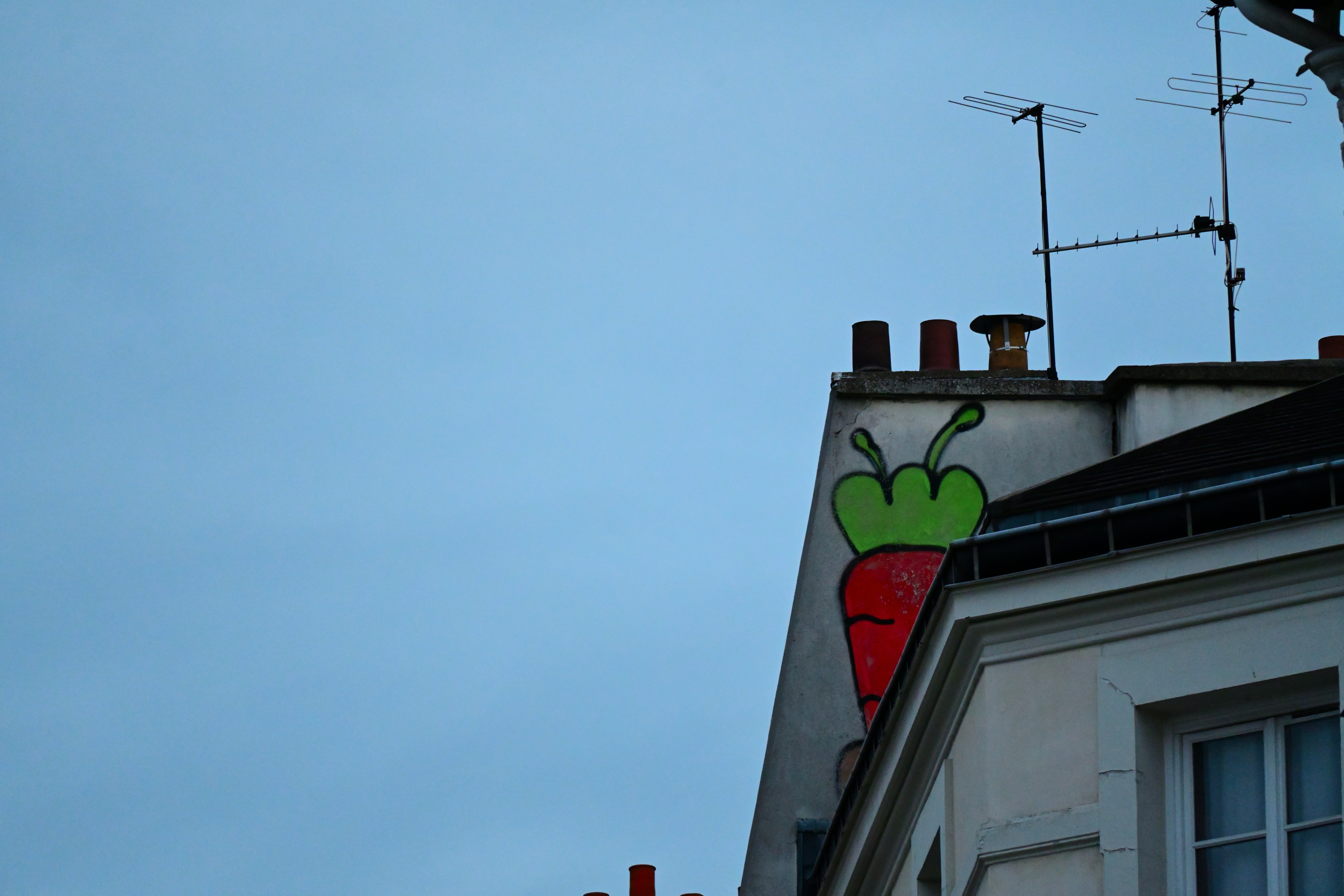 Rooftop mural peeking over a Parisian edge