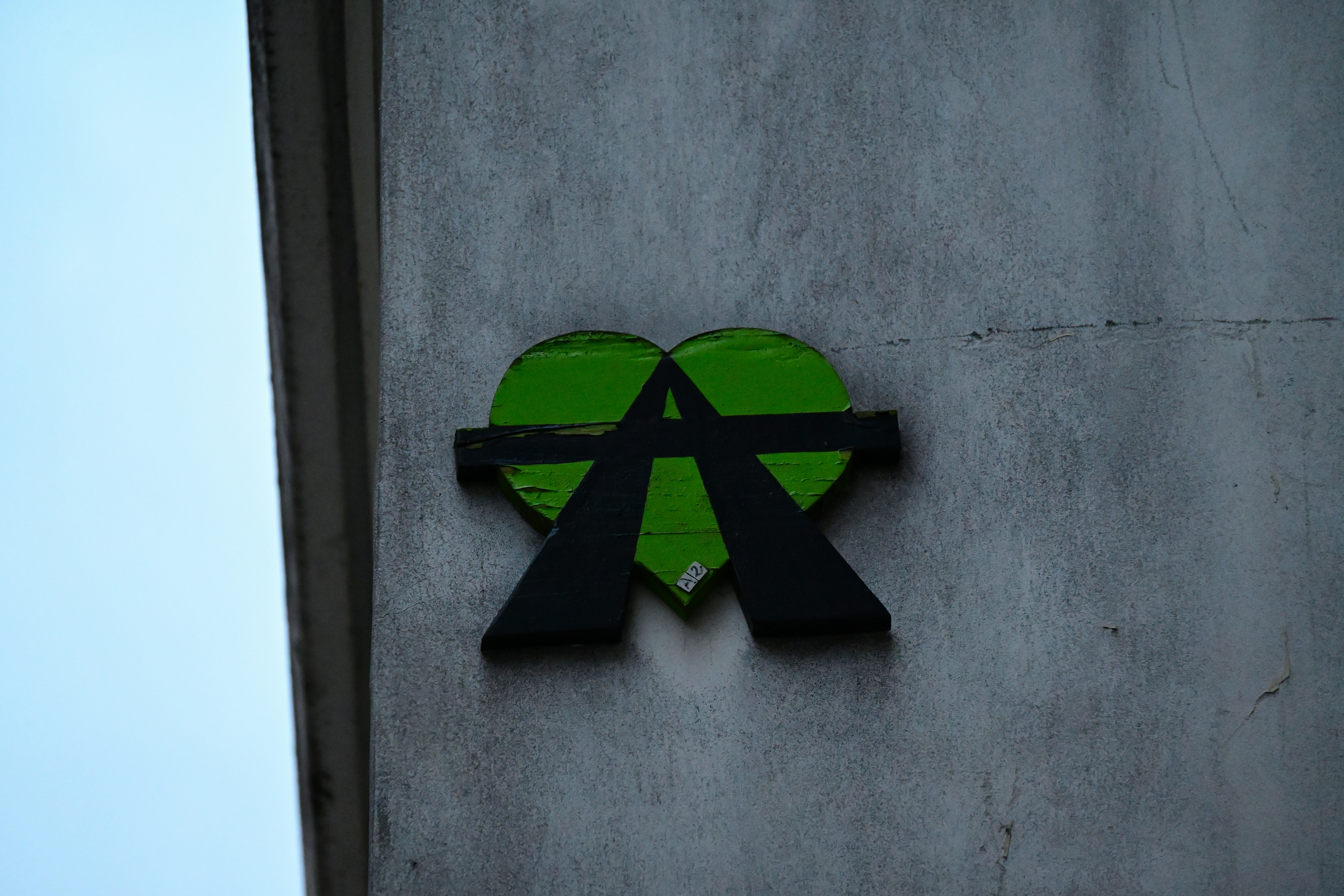 Green Heart Mark on Concrete Wall: A Minimal, Bold Logo Close-Up