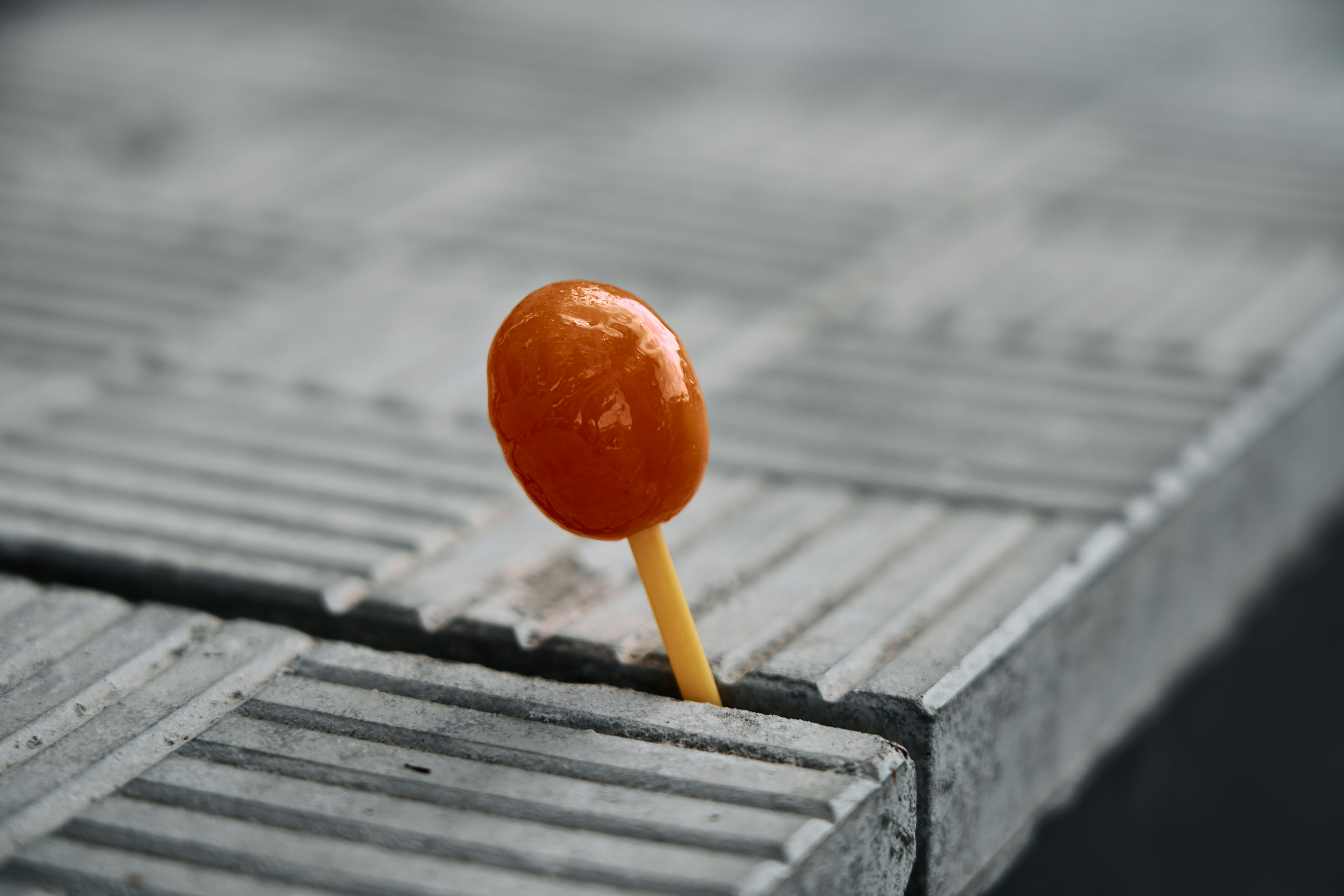 Orange Lollipop on a Concrete Step: A Single Pop of Color in a Quiet Stairwell