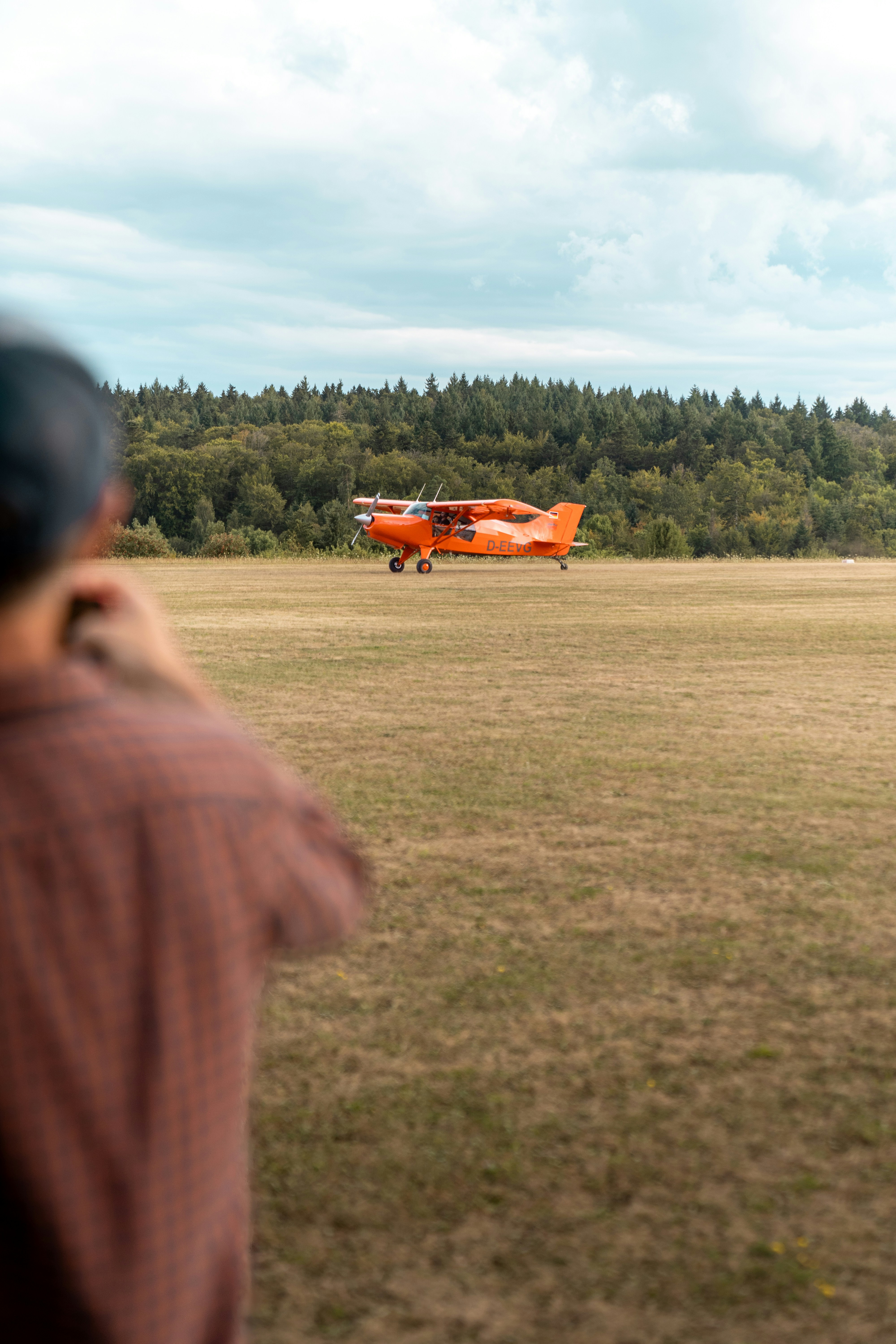 A person taking a picture of an orange plane photo – Free Germany Image ...