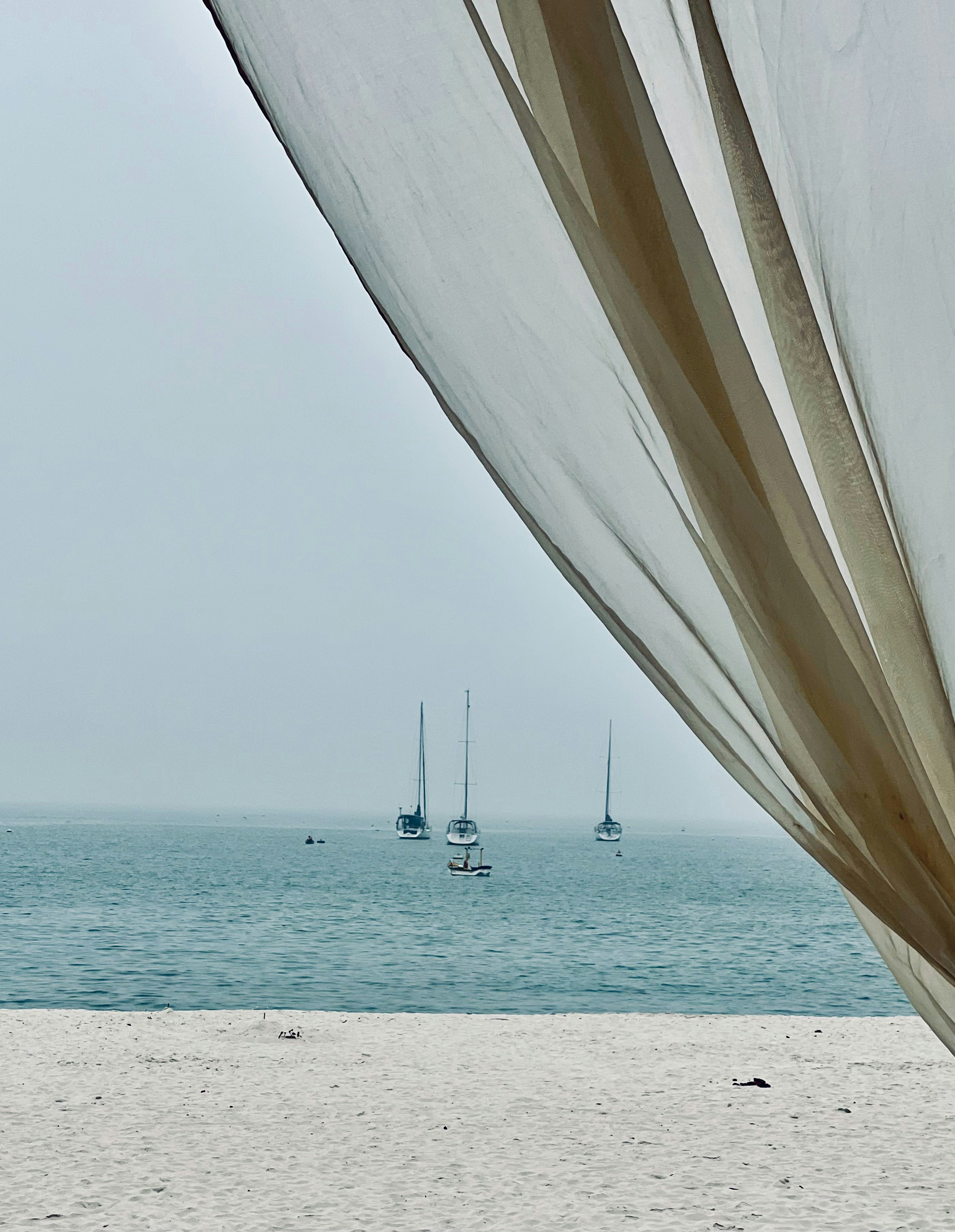 A view of a beach with sailboats in the distance photo – Free Sea Image ...