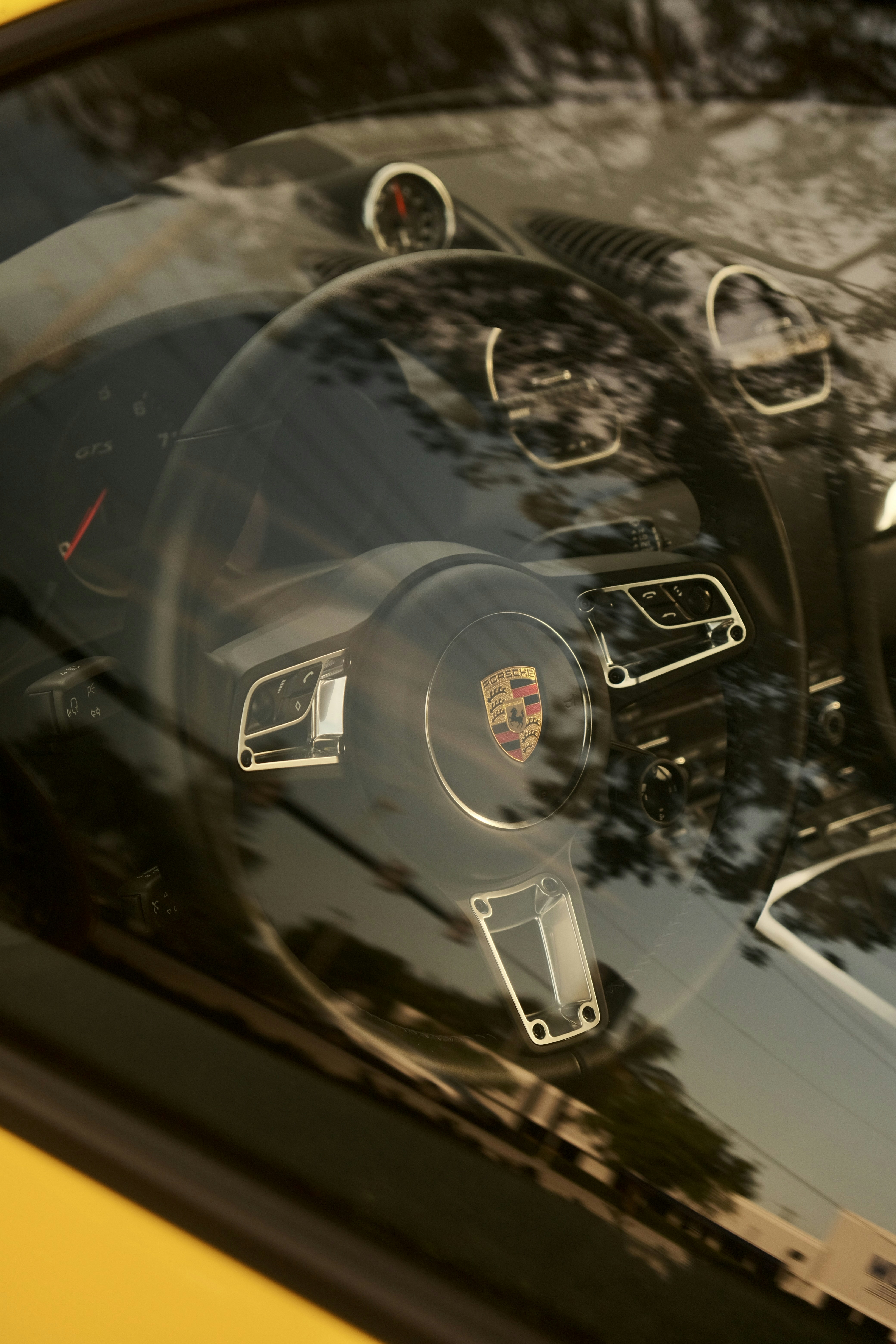 Glassbound Porsche: Reflections Carve a Quiet Cockpit Moment