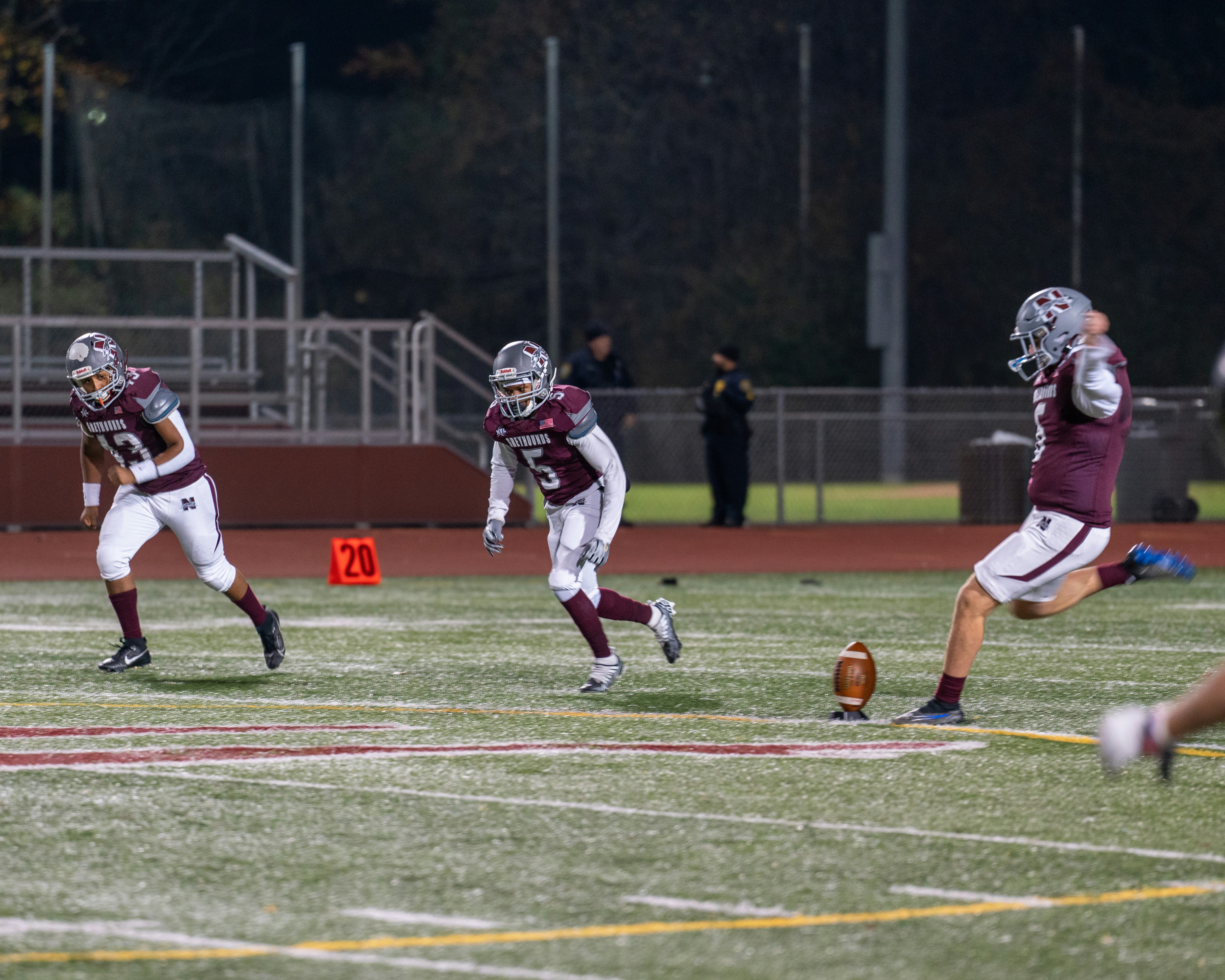Football players poised for a kickoff, showcasing teamwork and strategy on a well-lit field.