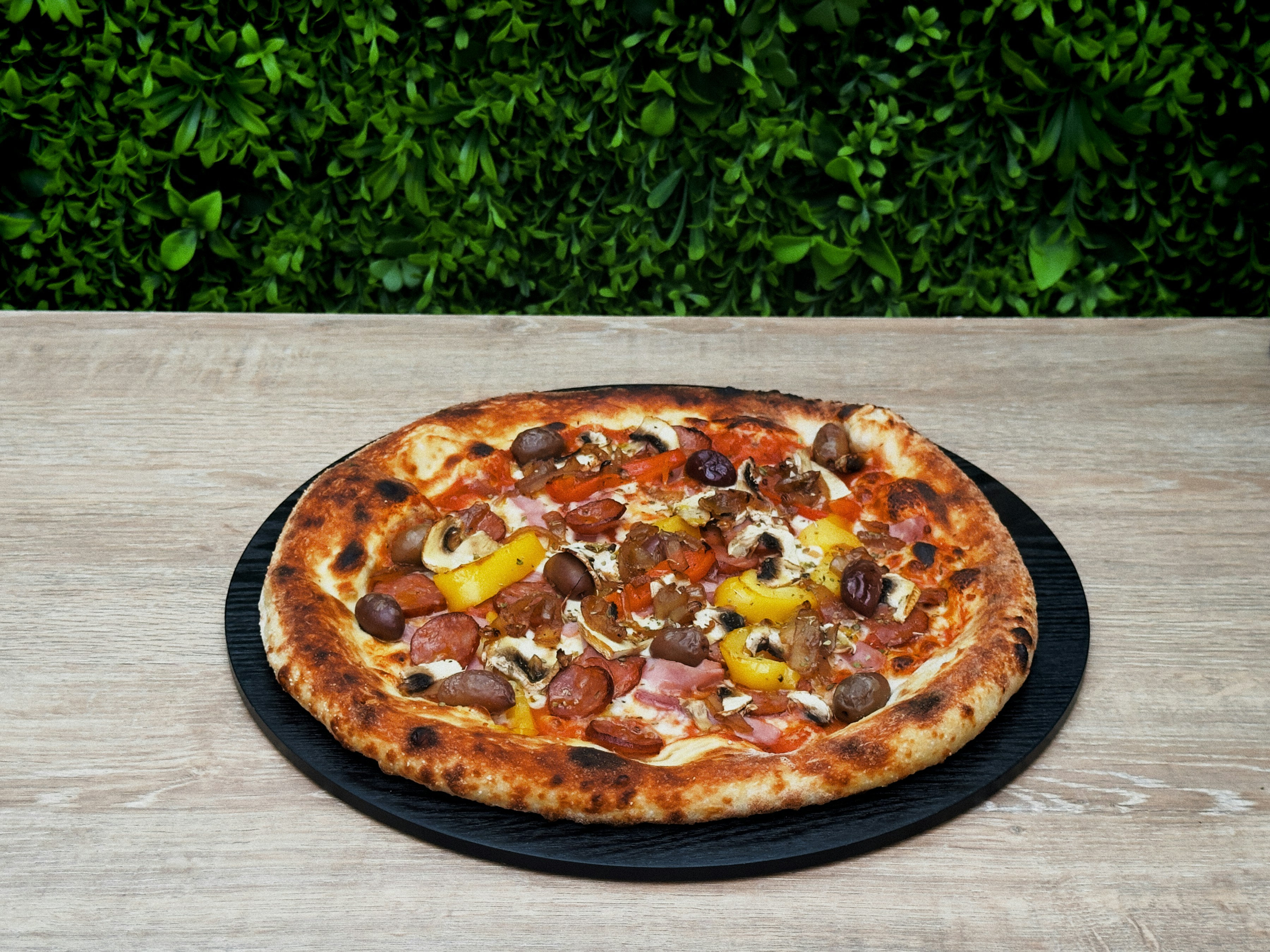 Verdant Backdrop, Rustic Plate: A Centered Pizza Portrait