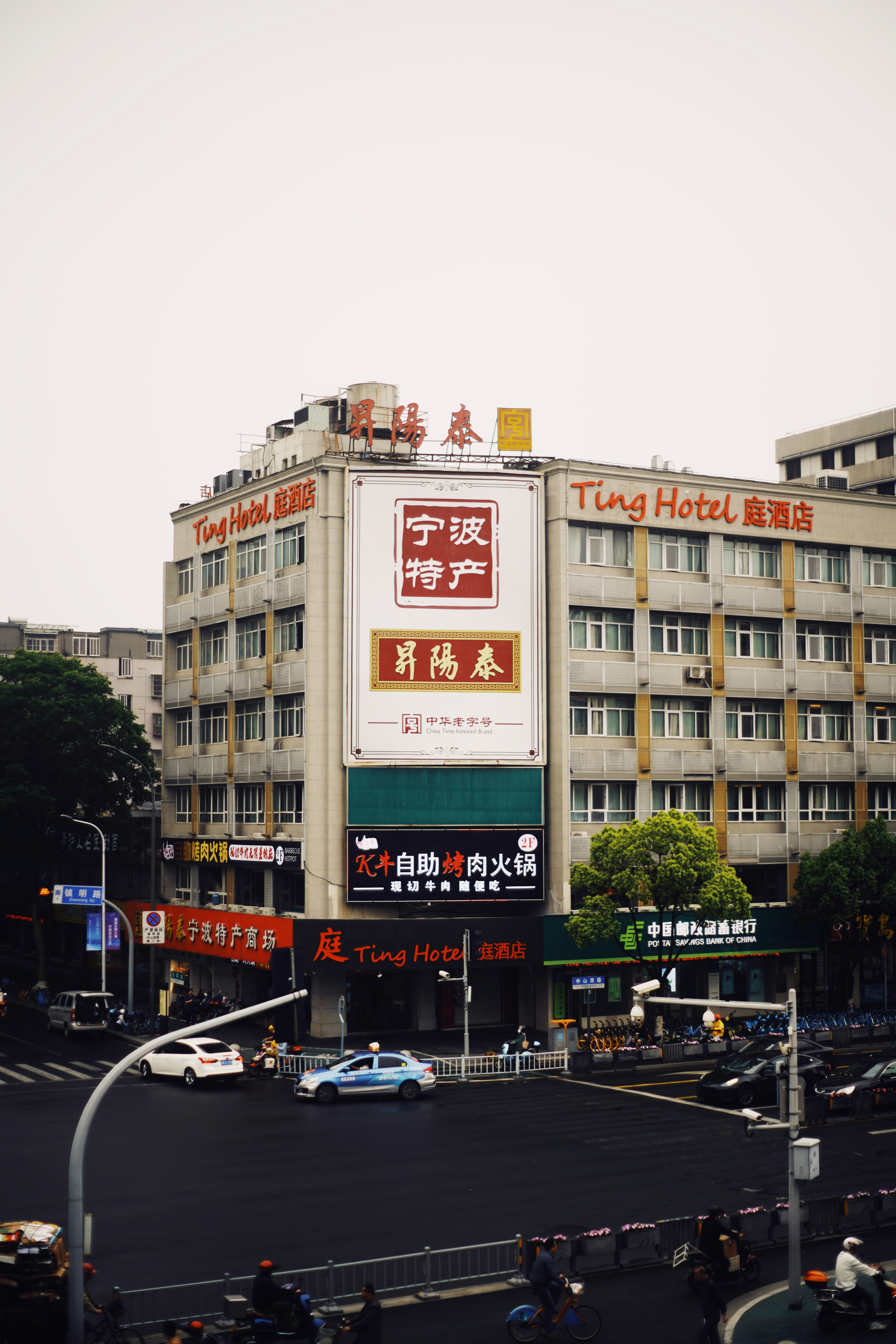 Central Chinese Billboard Anchors a Bustling Hotel Block on a City Street