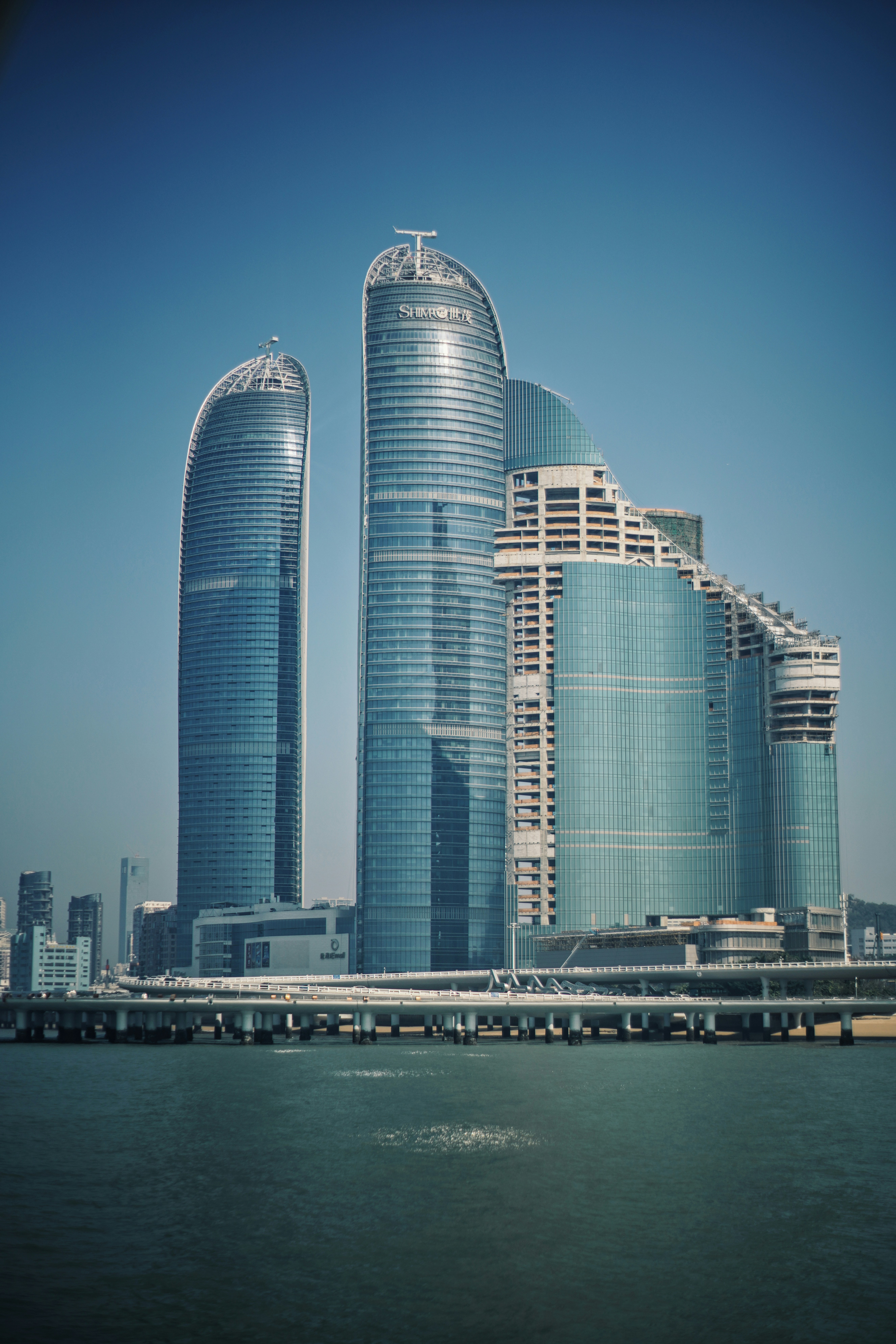 Cobalt Skyline: Trio of Curved Glass Towers Over a Calm Marina