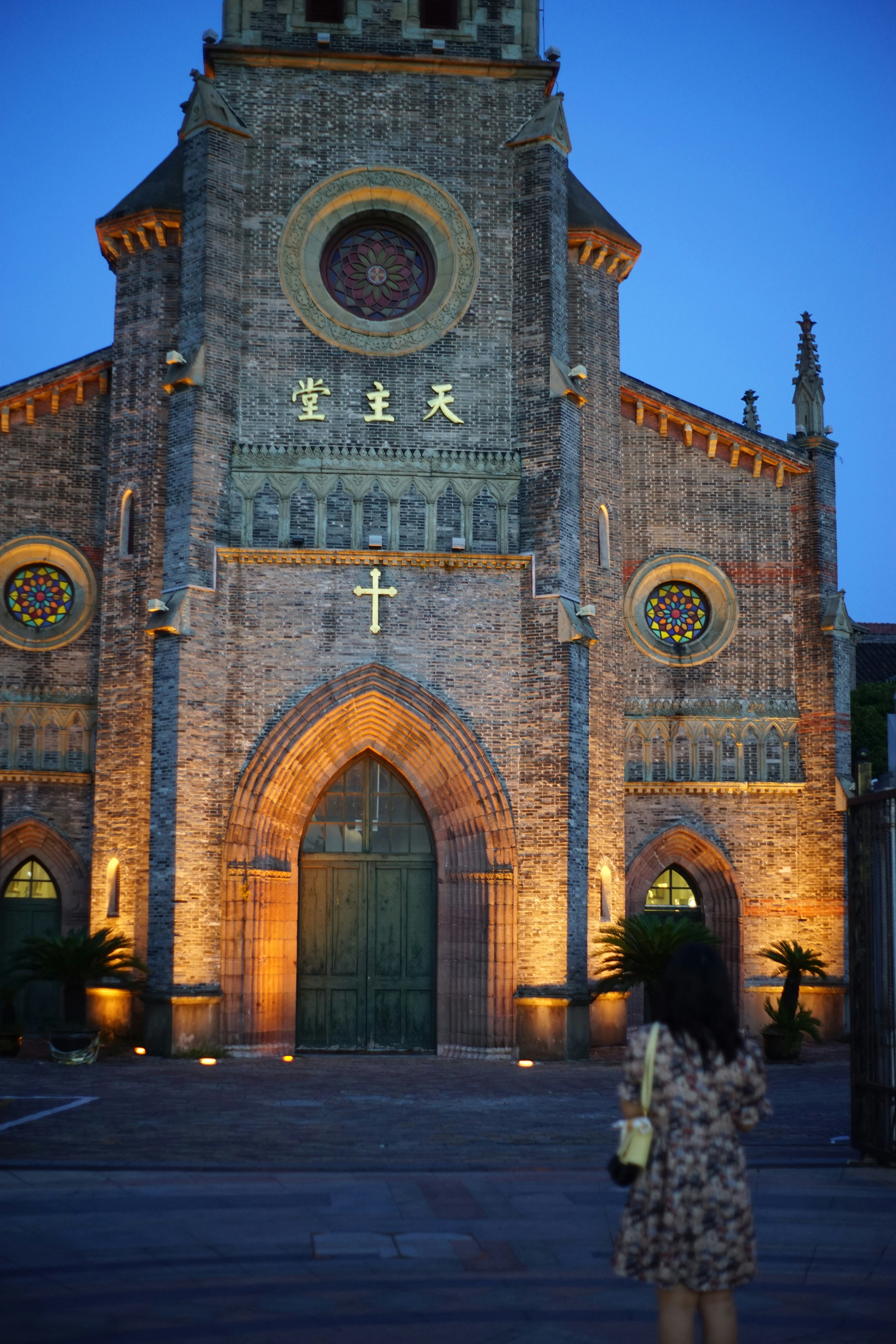 Evening Glow on a Brick Cathedral: Central Archway and Rose Windows