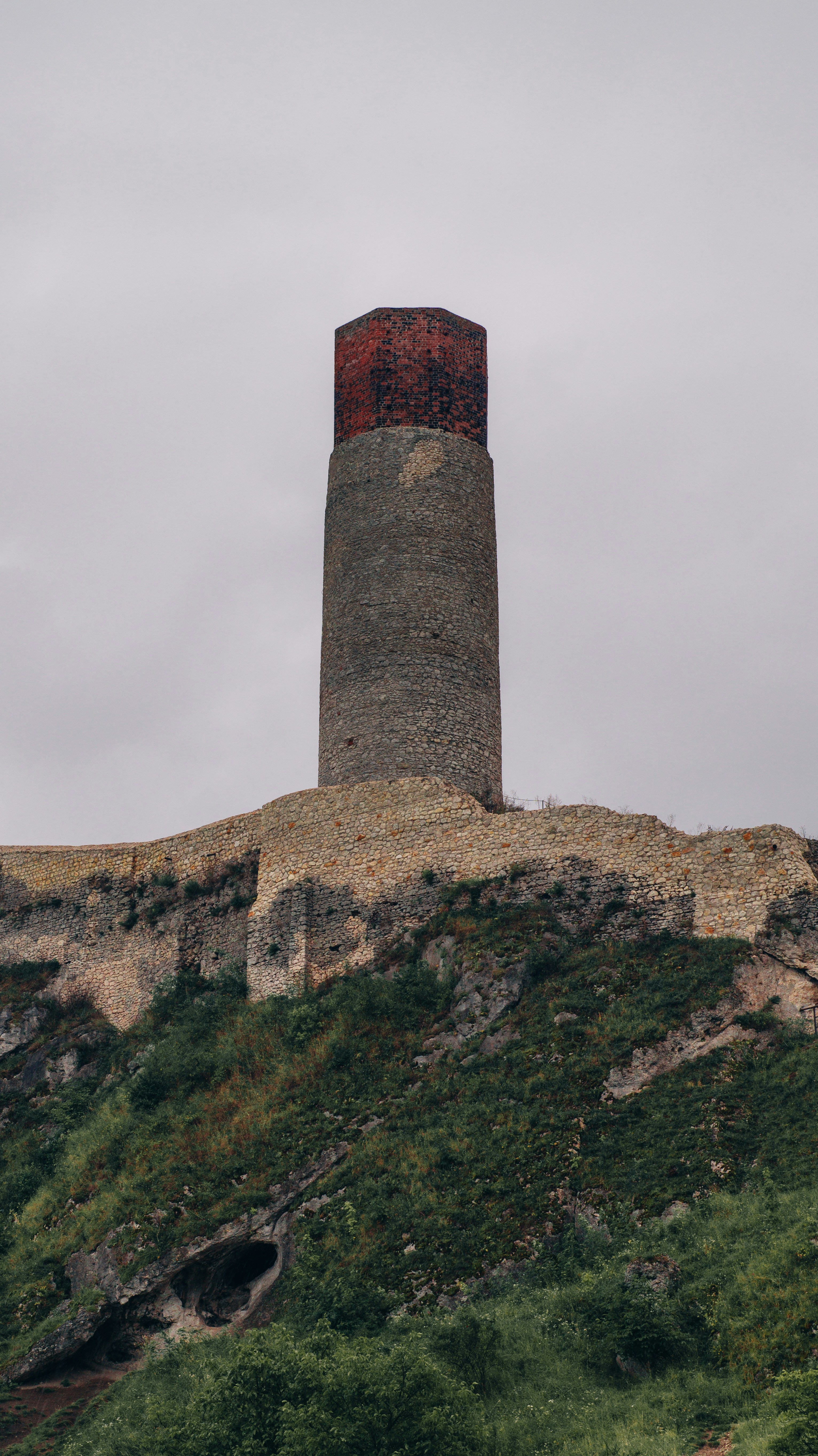 Chimney Sentinel on a Moss-Covered Ridge Under Grey Skies