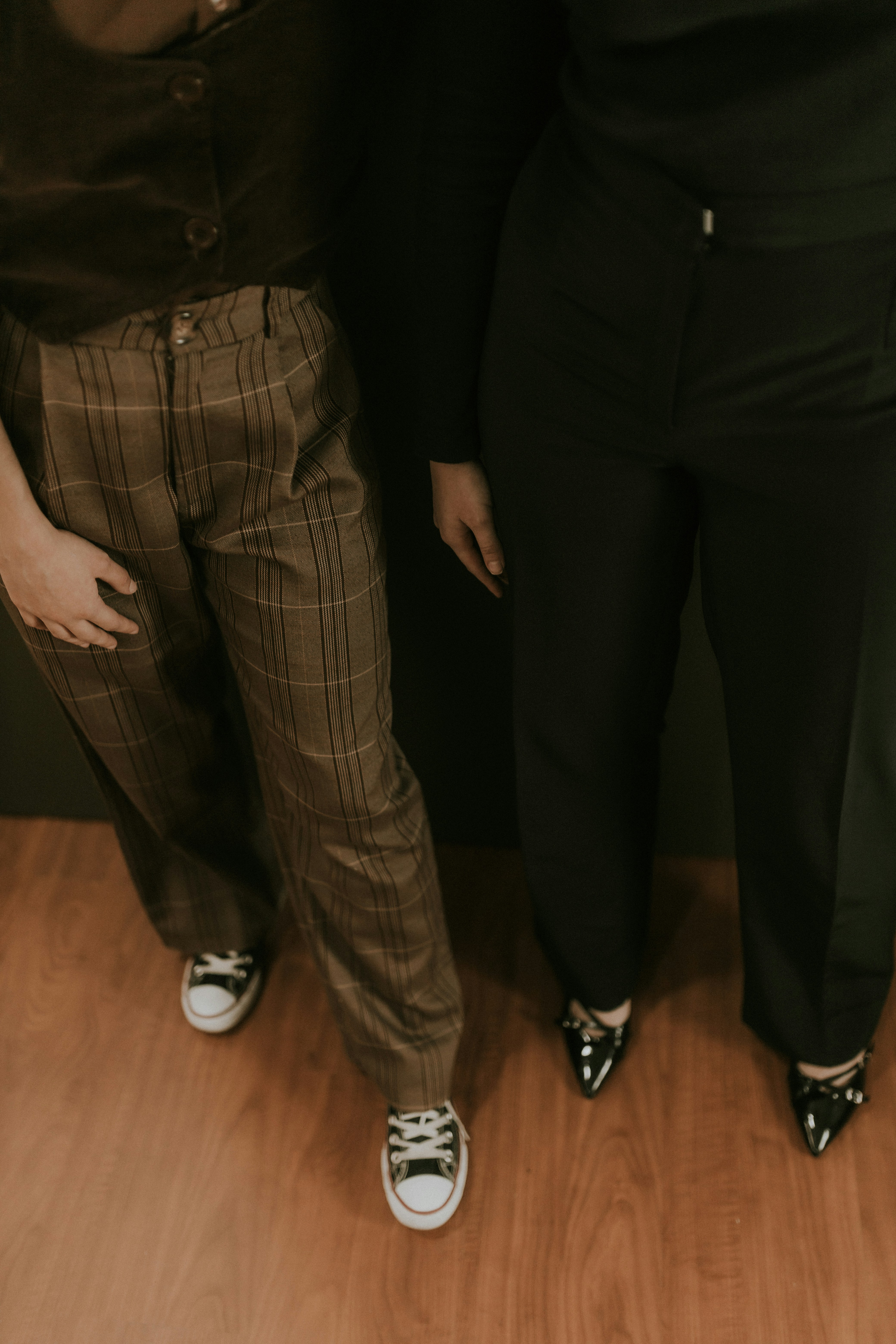Grounded in Style: Plaid Trousers vs Black Slacks on a Warm Wood Floor