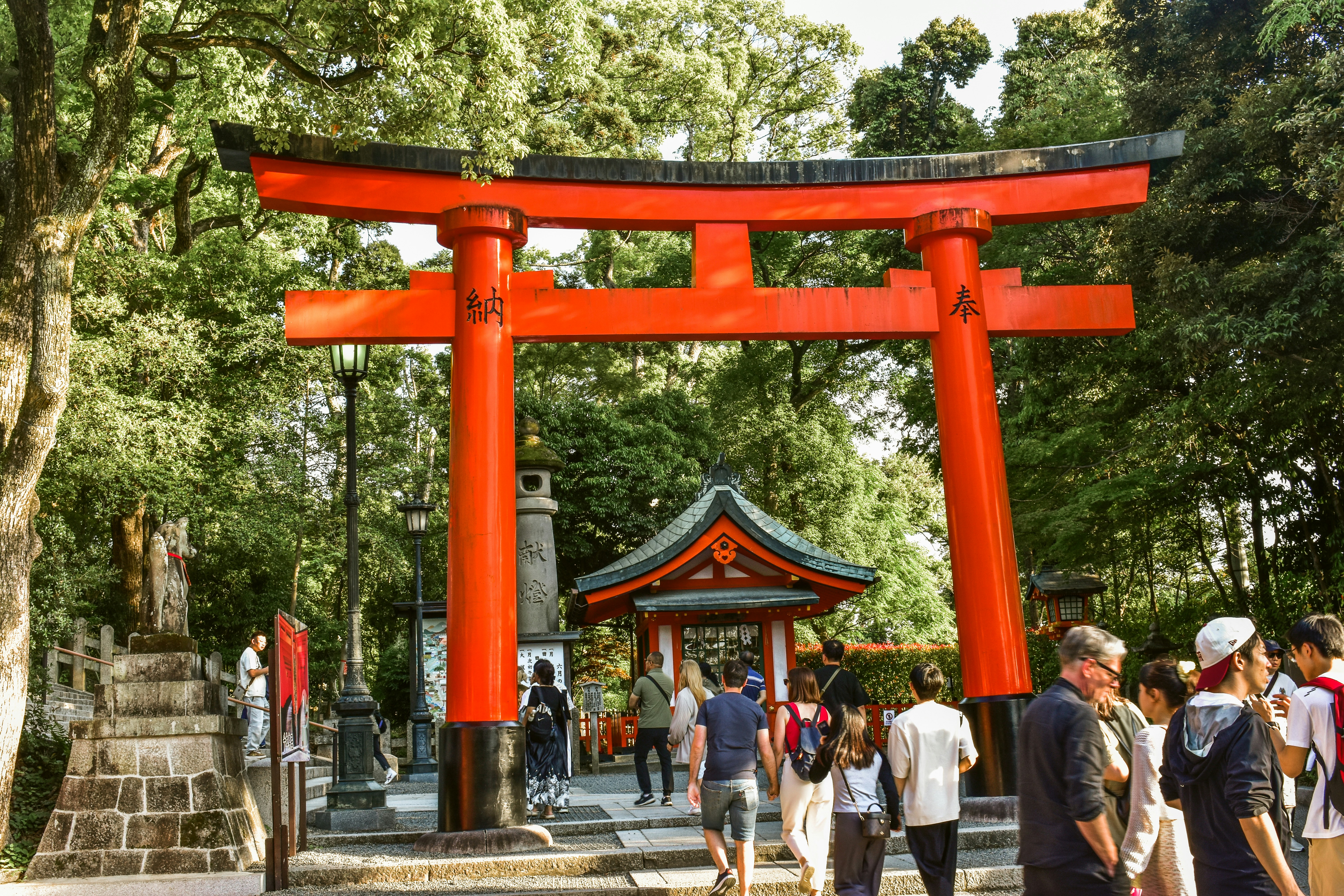 A group of people standing in front of a red gate photo – Free Man ...