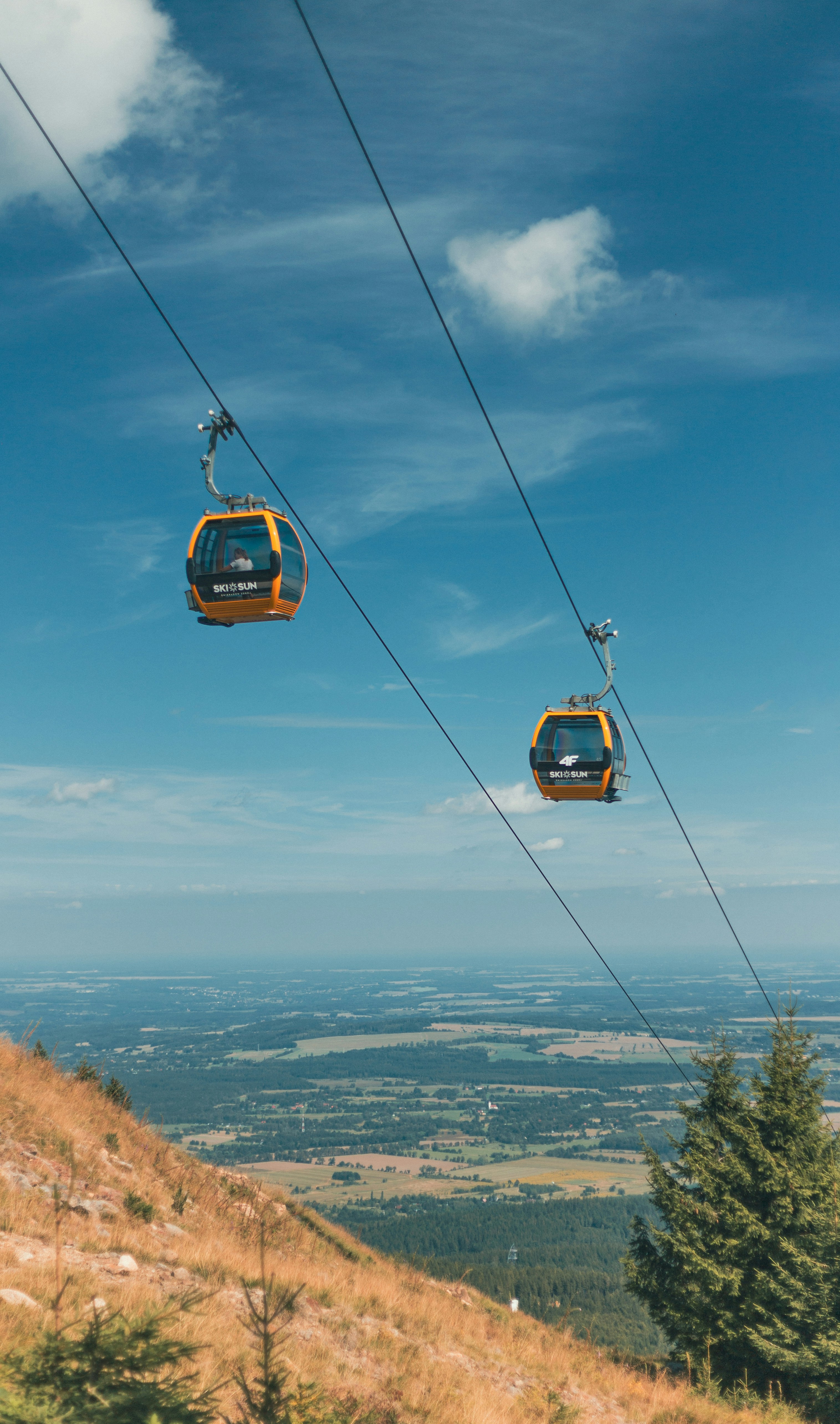 Orange Gondolas Traversing a Sky-Blue Alpine Panorama