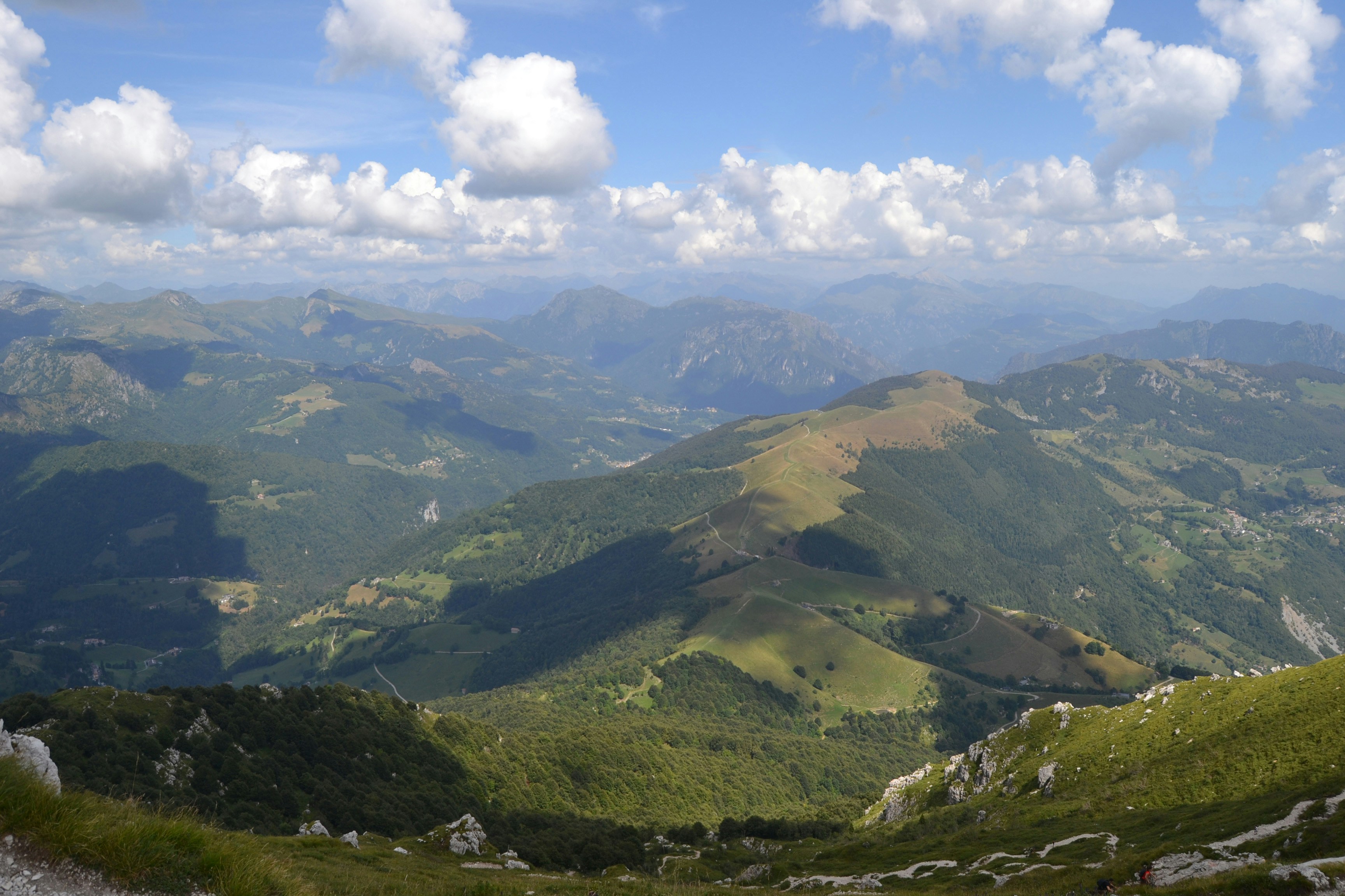 Expansive mountain range under a sky dotted with fluffy clouds.