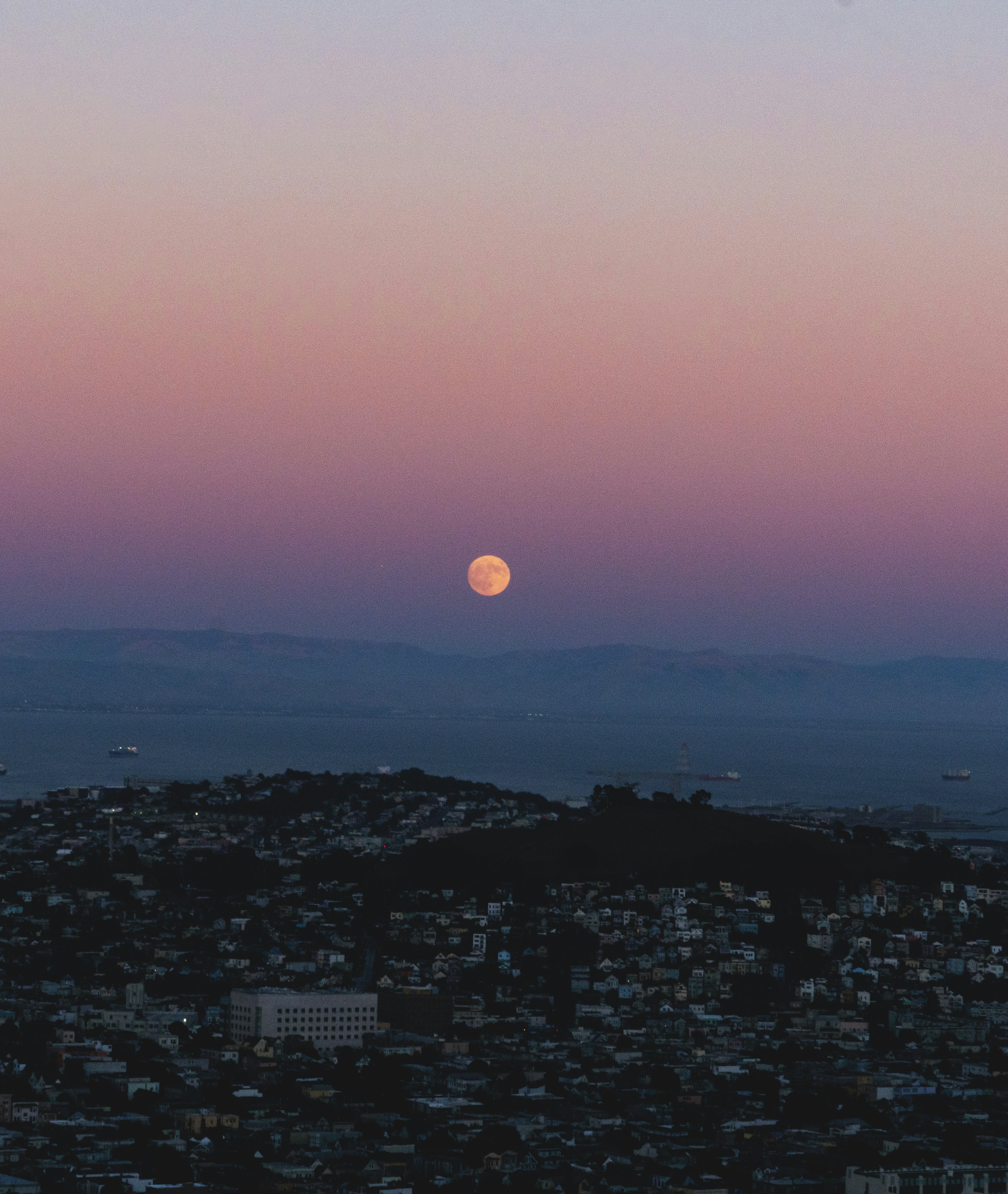 Moonrise over a Quiet Coastal City at Sunset