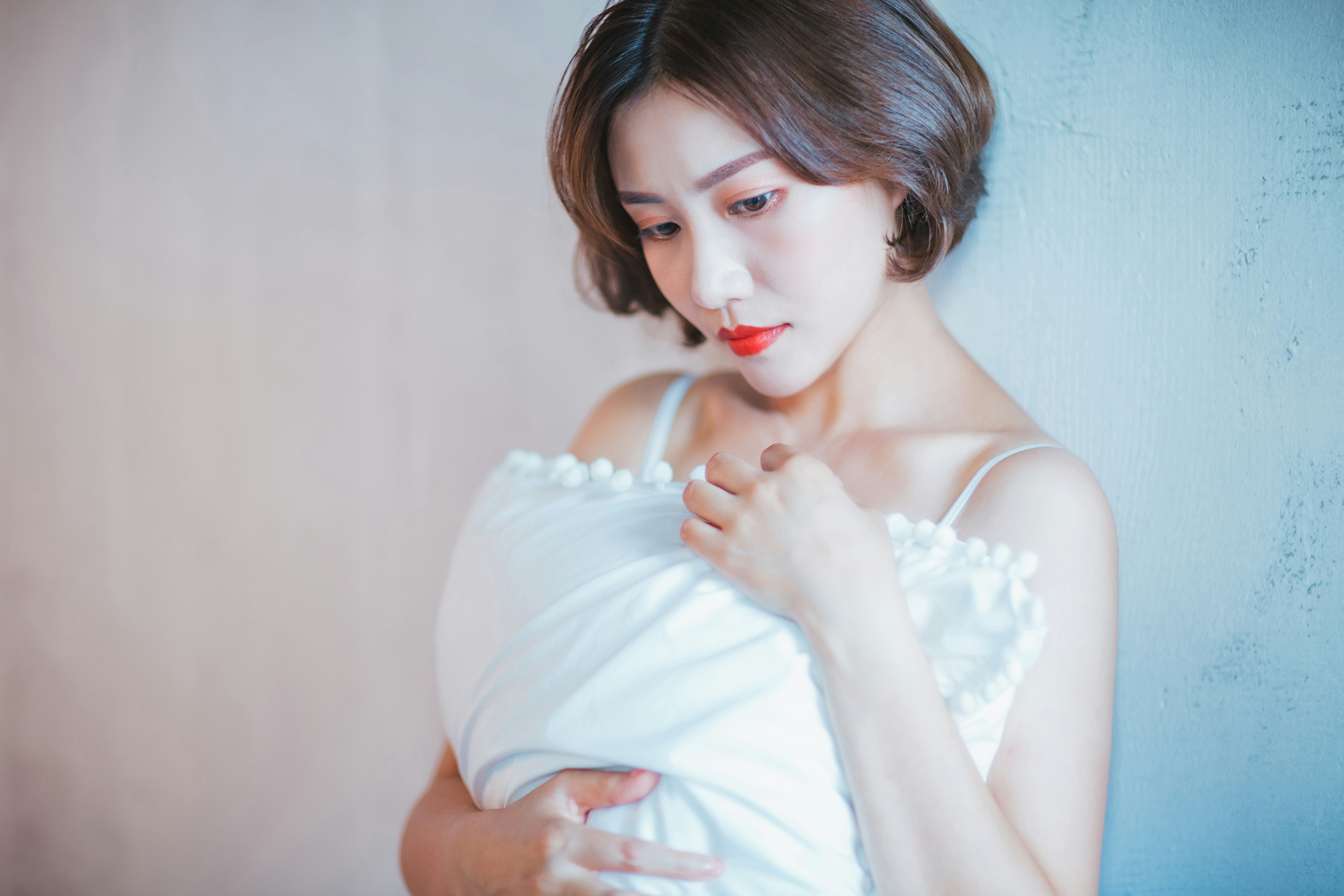 A woman in a white dress holding a baby photo – Free Portrait Image on ...