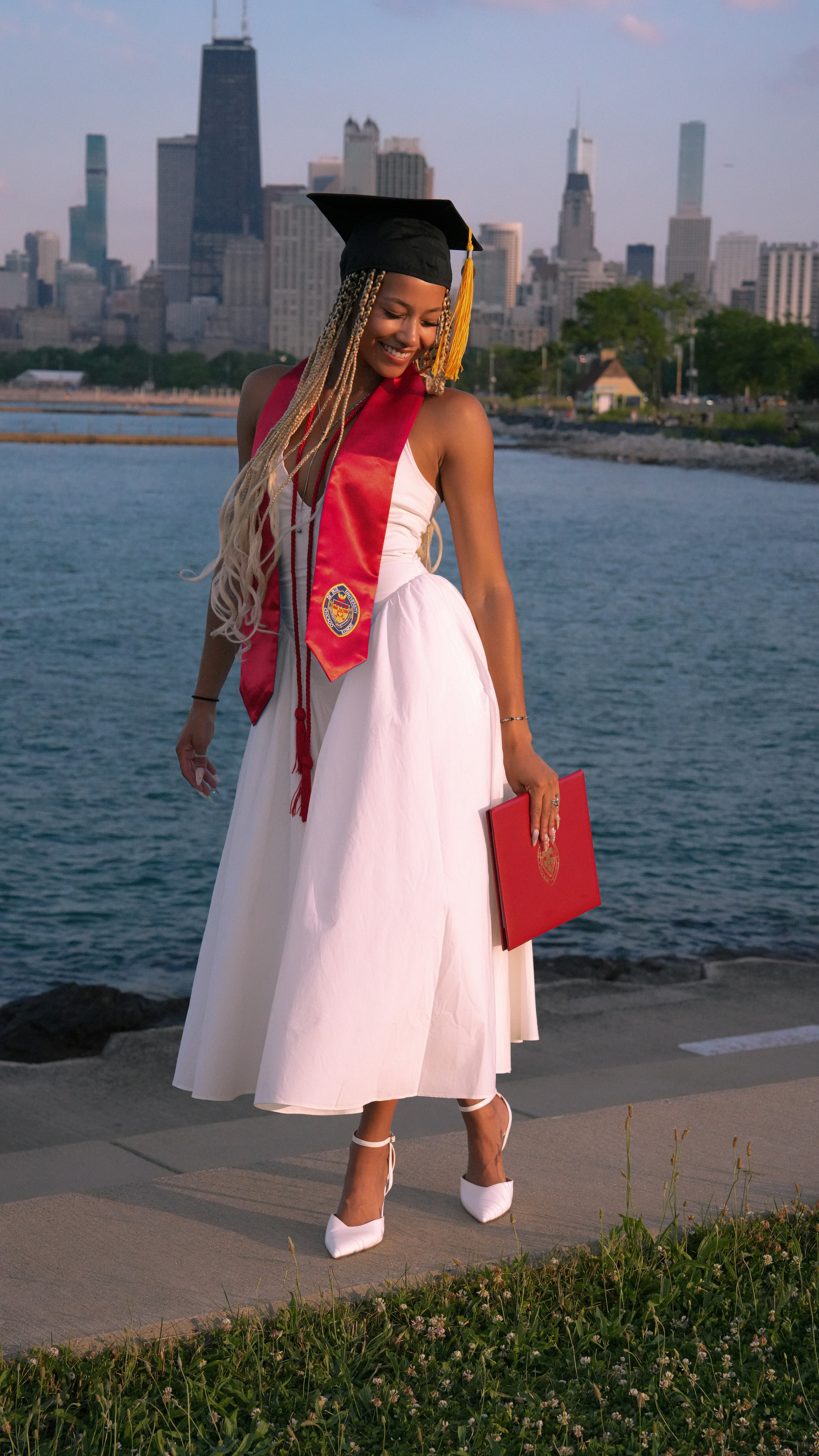 Crimson Stole, White Dress, and Waterfront Skyline: A Graduation Portrait by the City