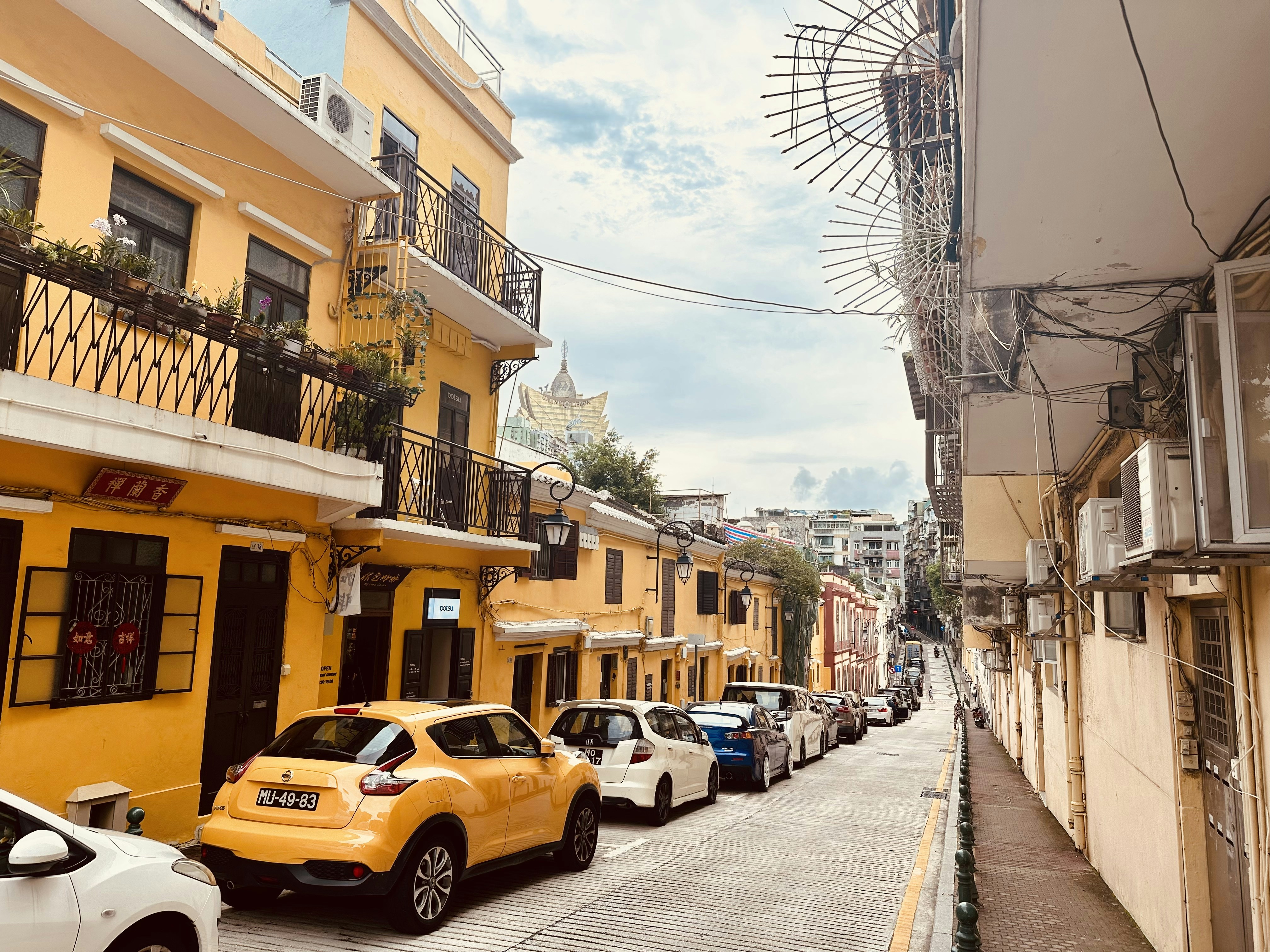 A row of yellow buildings on a city street photo – Free Macau Image on ...
