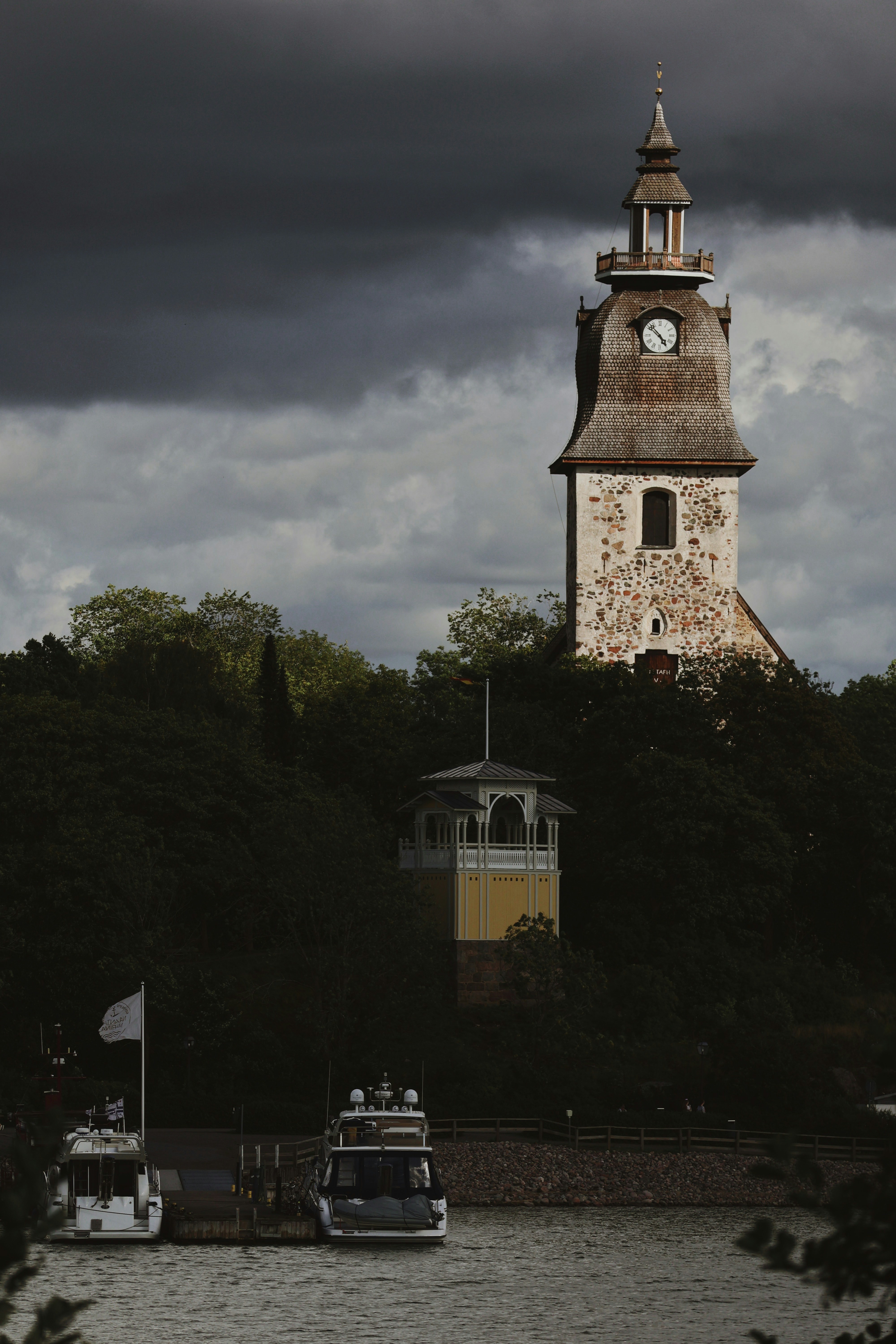 A large clock tower towering over a body of water photo – Free Finland ...