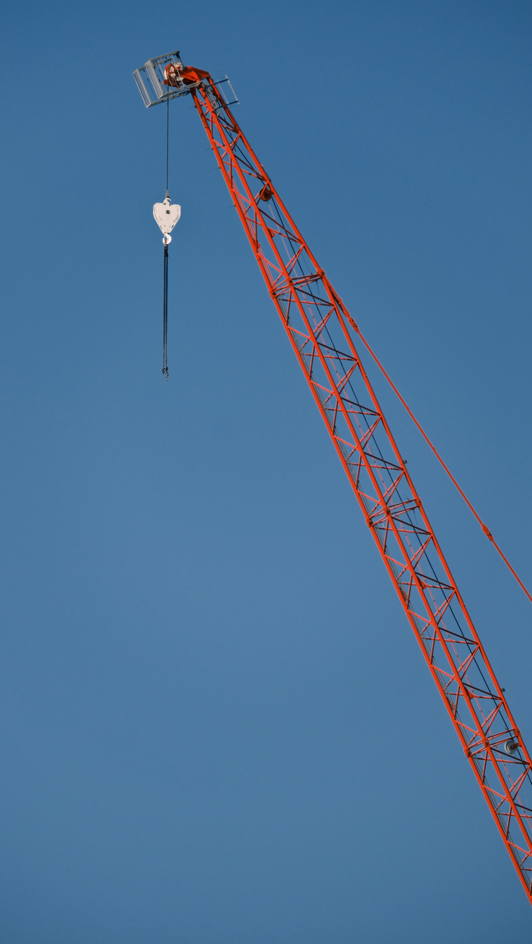 Crimson Lattice Crane Against a Cerulean Sky