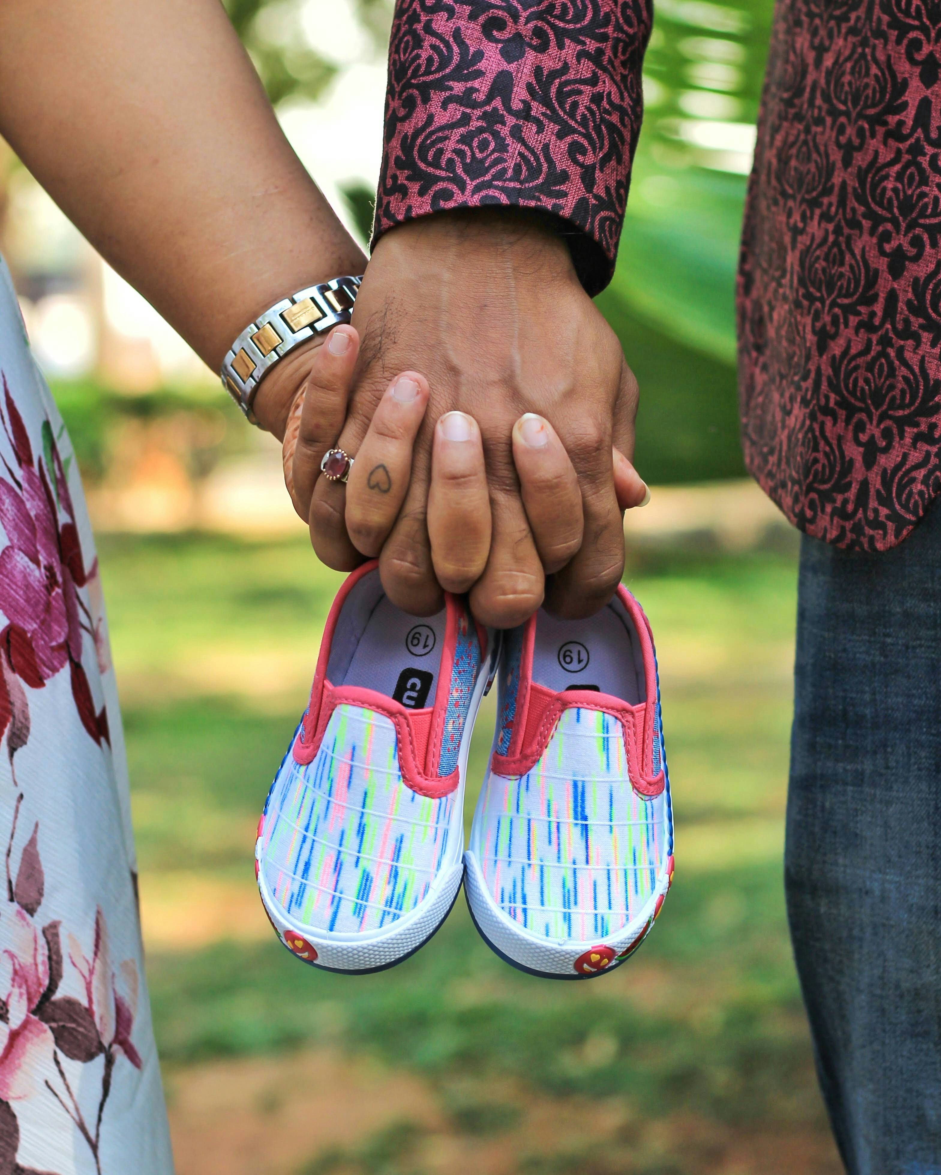 Holding Hands, Sharing Soles: A Quiet Moment in Colorful Slippers