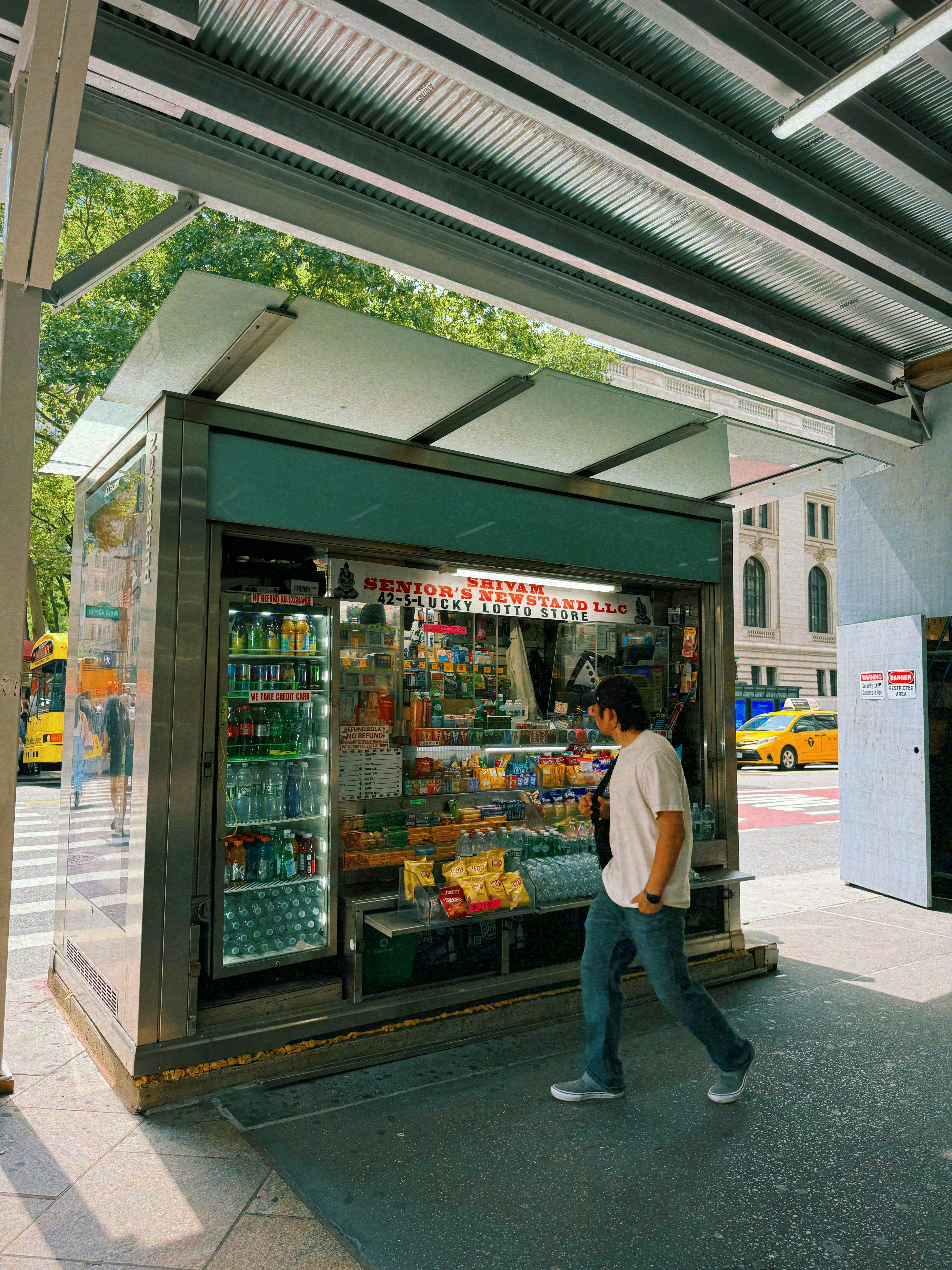 A man walking past a vending machine on a sidewalk photo – Free Man ...
