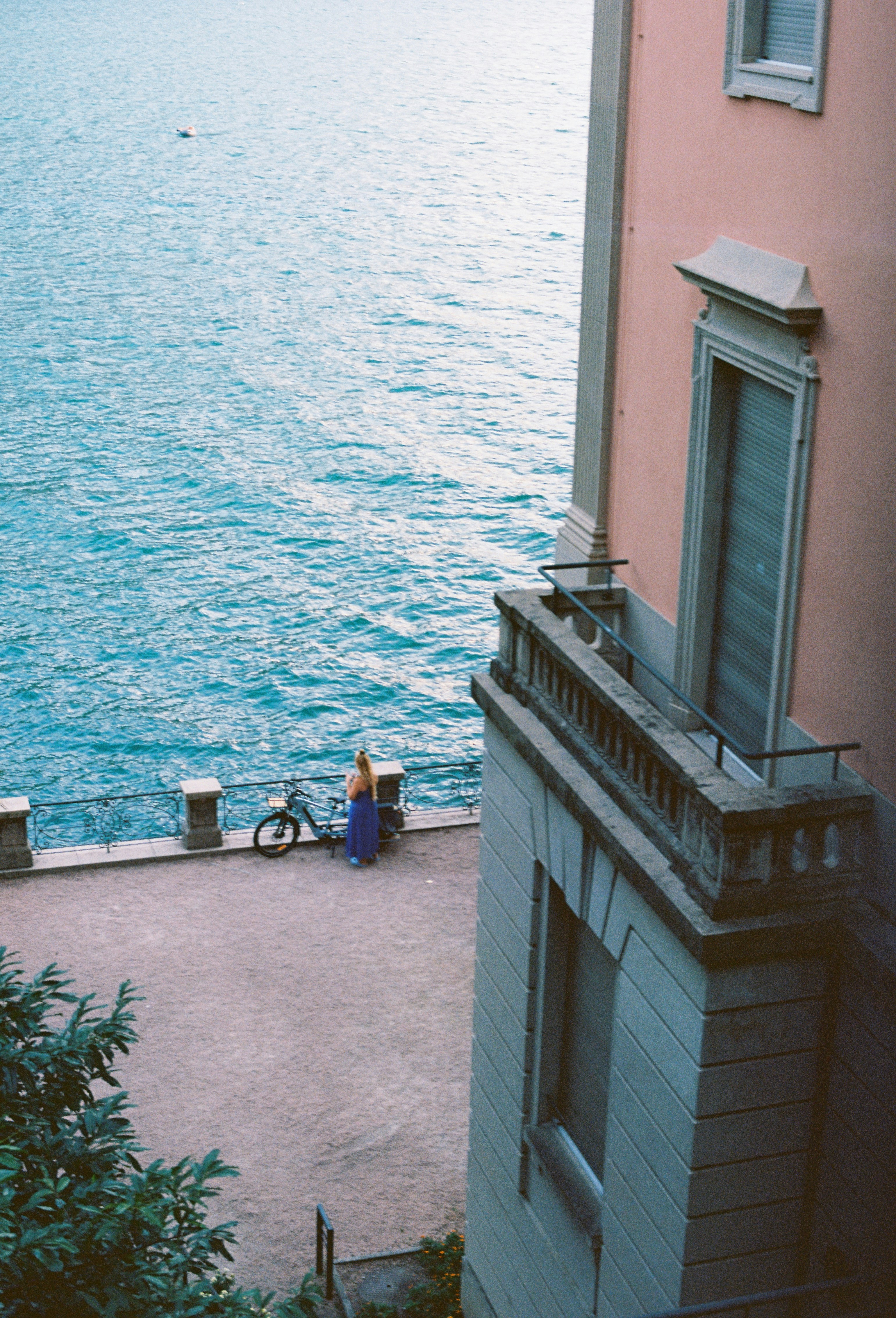 A person sitting on a balcony overlooking a body of water photo – Free ...