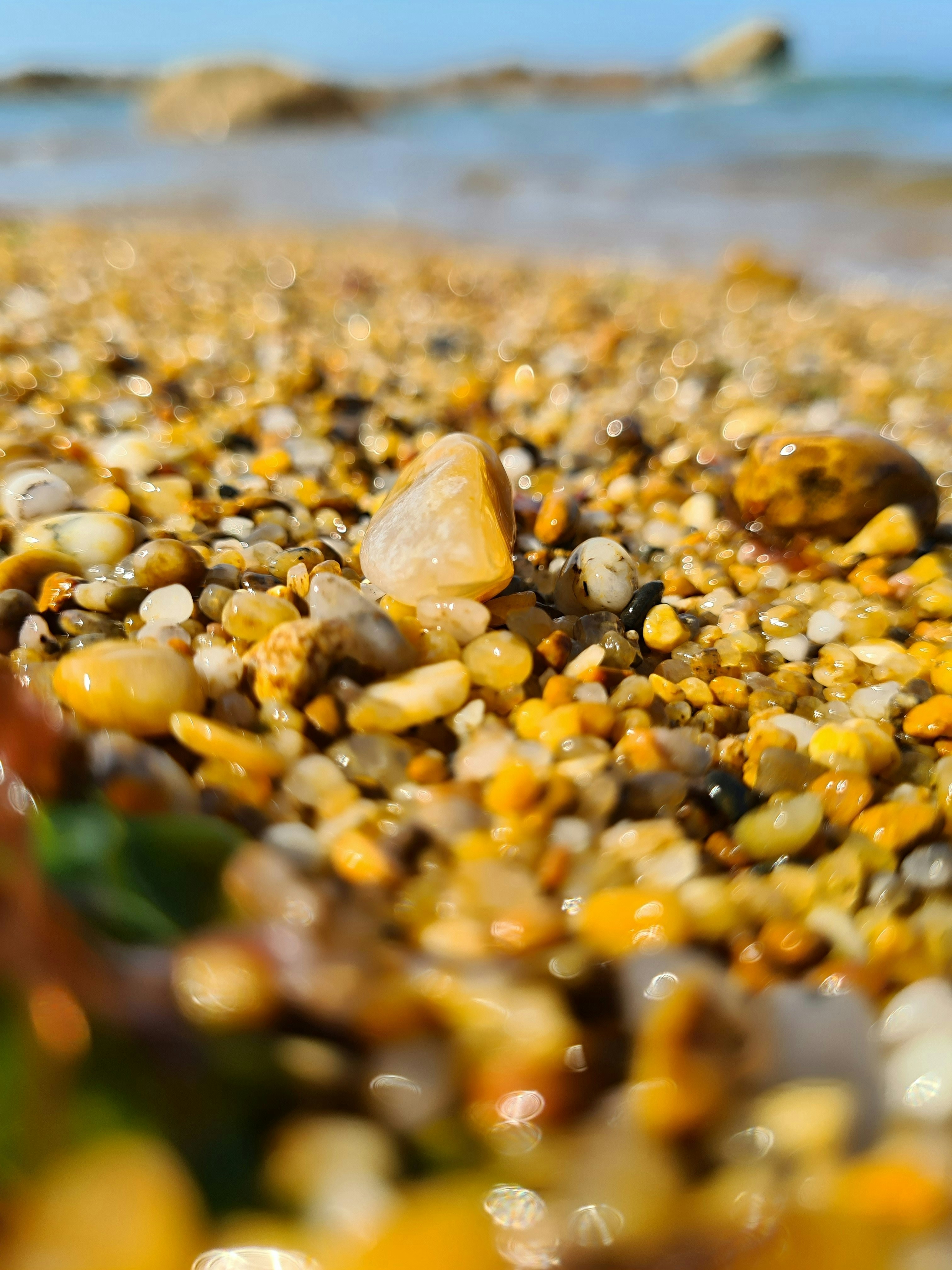 Sunlit Pebble Mosaic: A Macro View of Shine and Color on the Shore