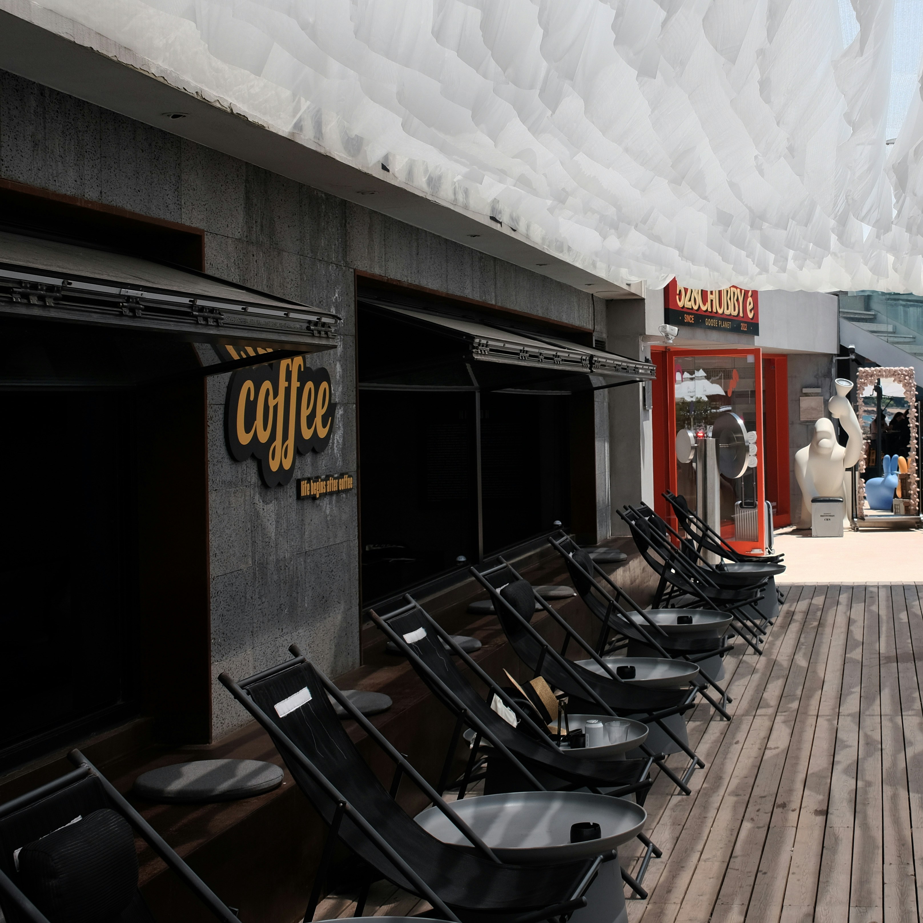 A row of black chairs sitting on top of a wooden floor