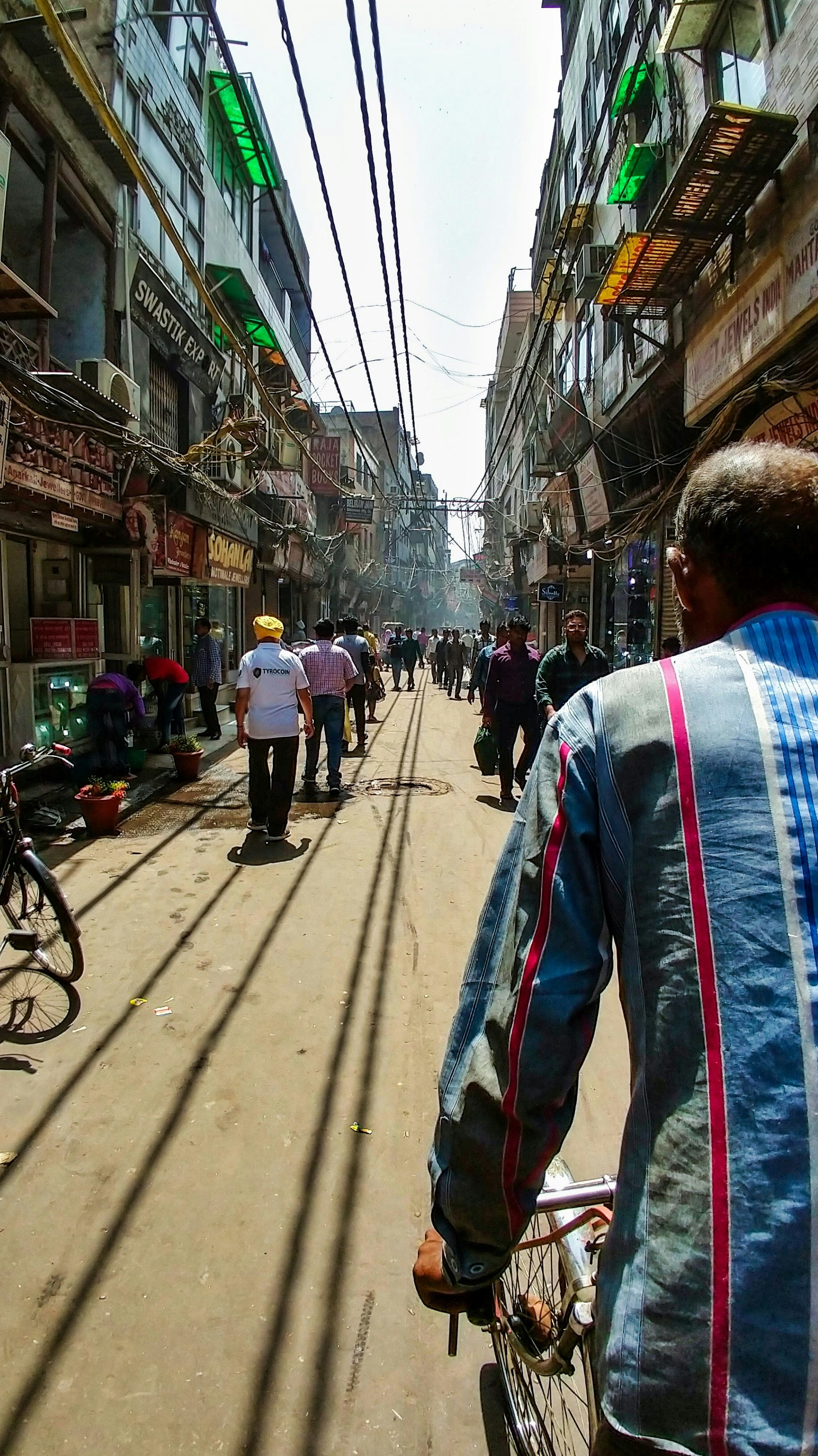 A man riding a bike down a street next to tall buildings