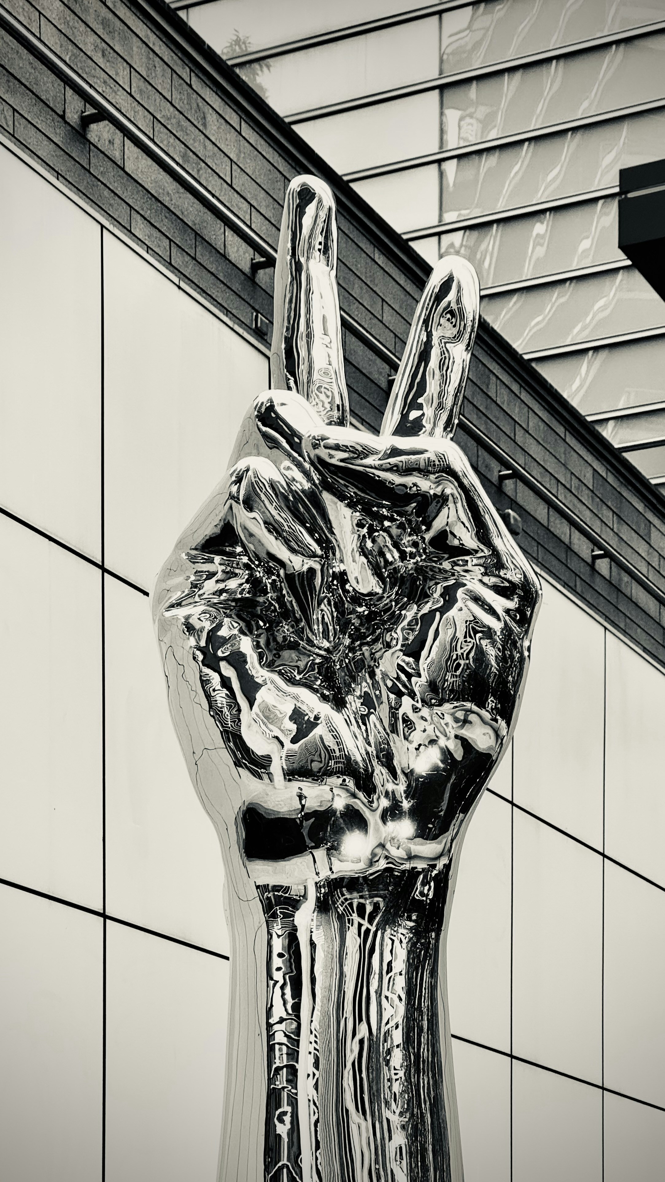 Chrome Peace: A Metallic Gesture in Vertical Light