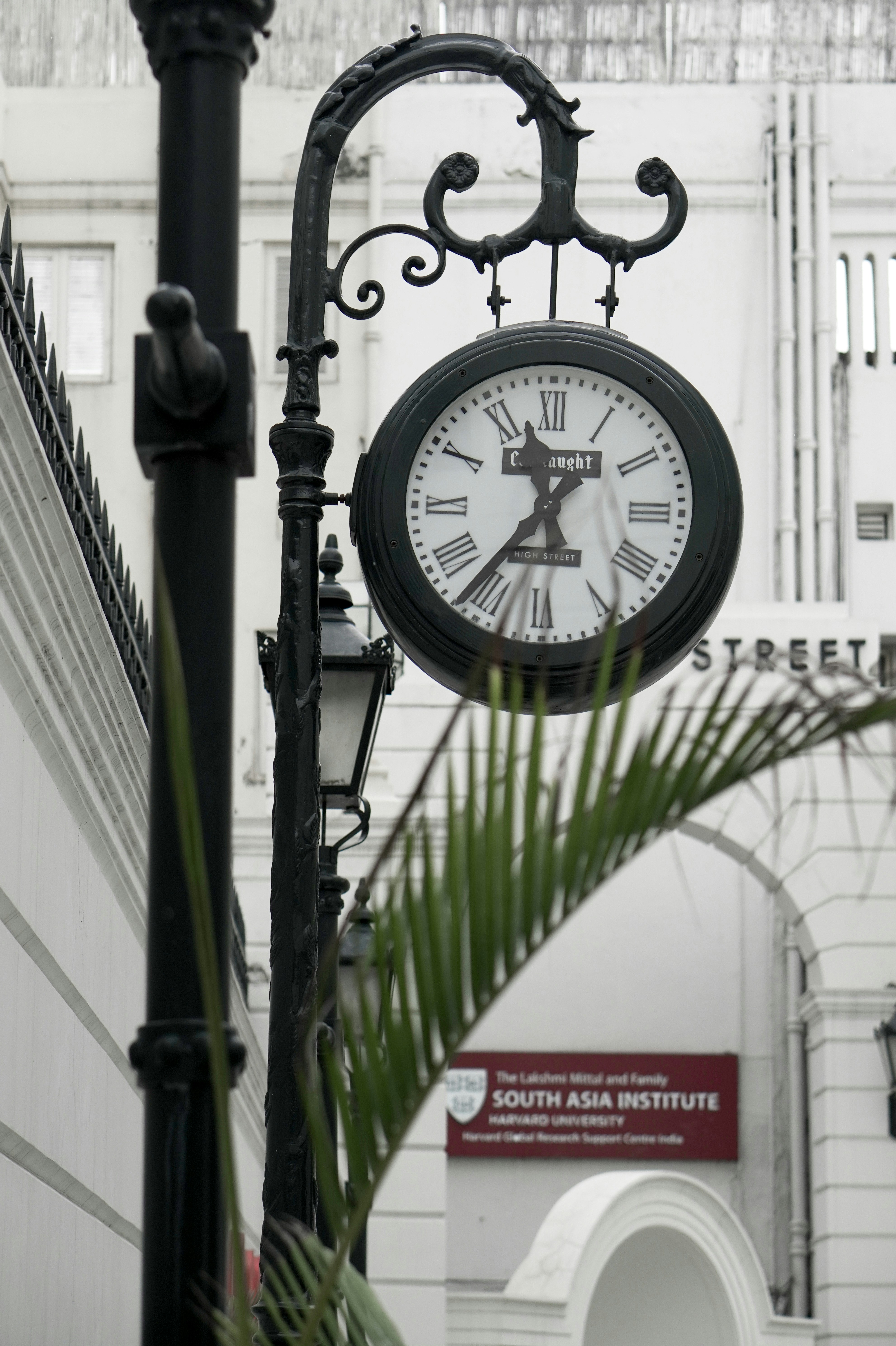 A clock on a pole in front of a building photo – Free Clock Image on ...