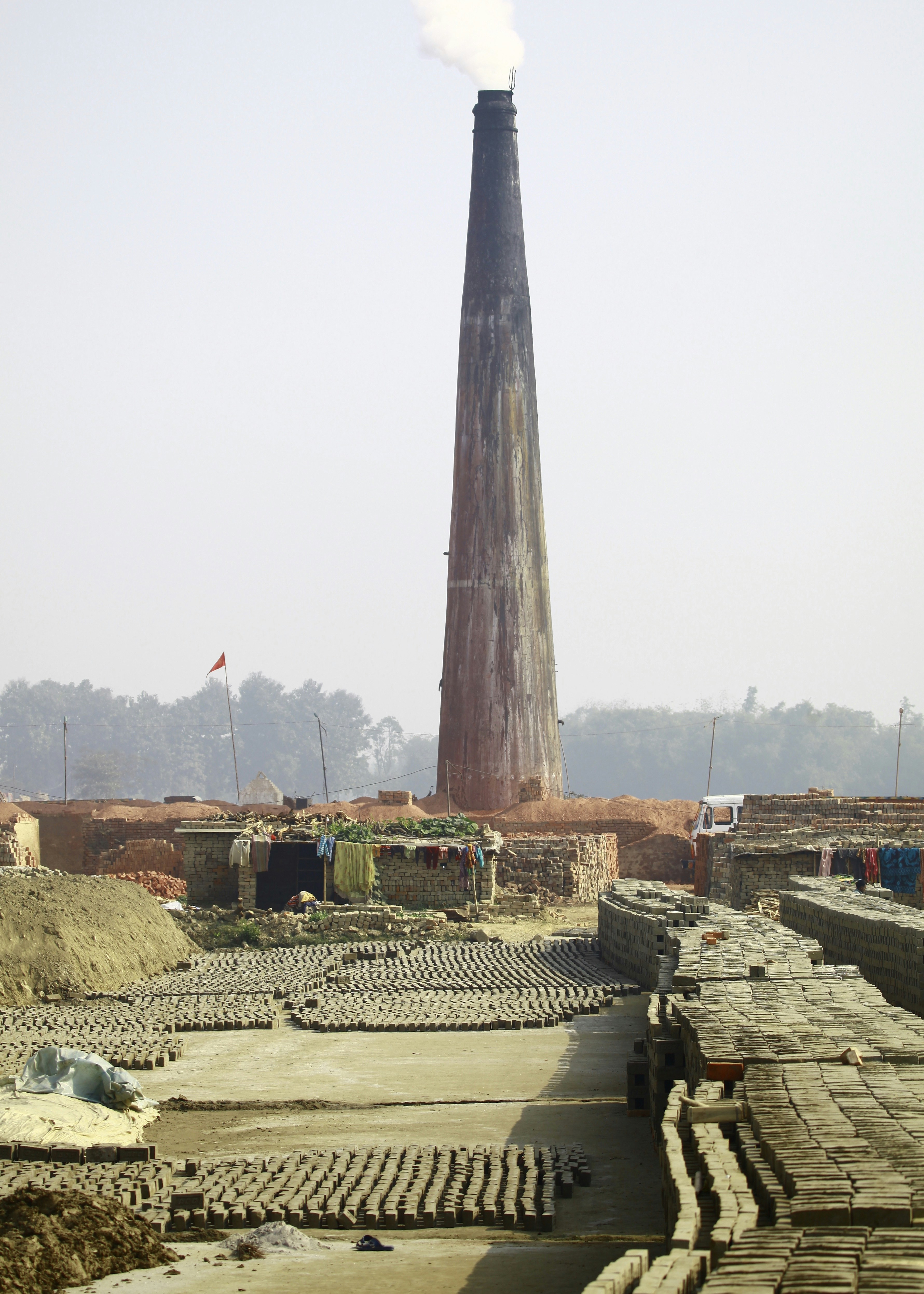Smoke Rising Above a Brick Chimney in a Vast Industrial Yard