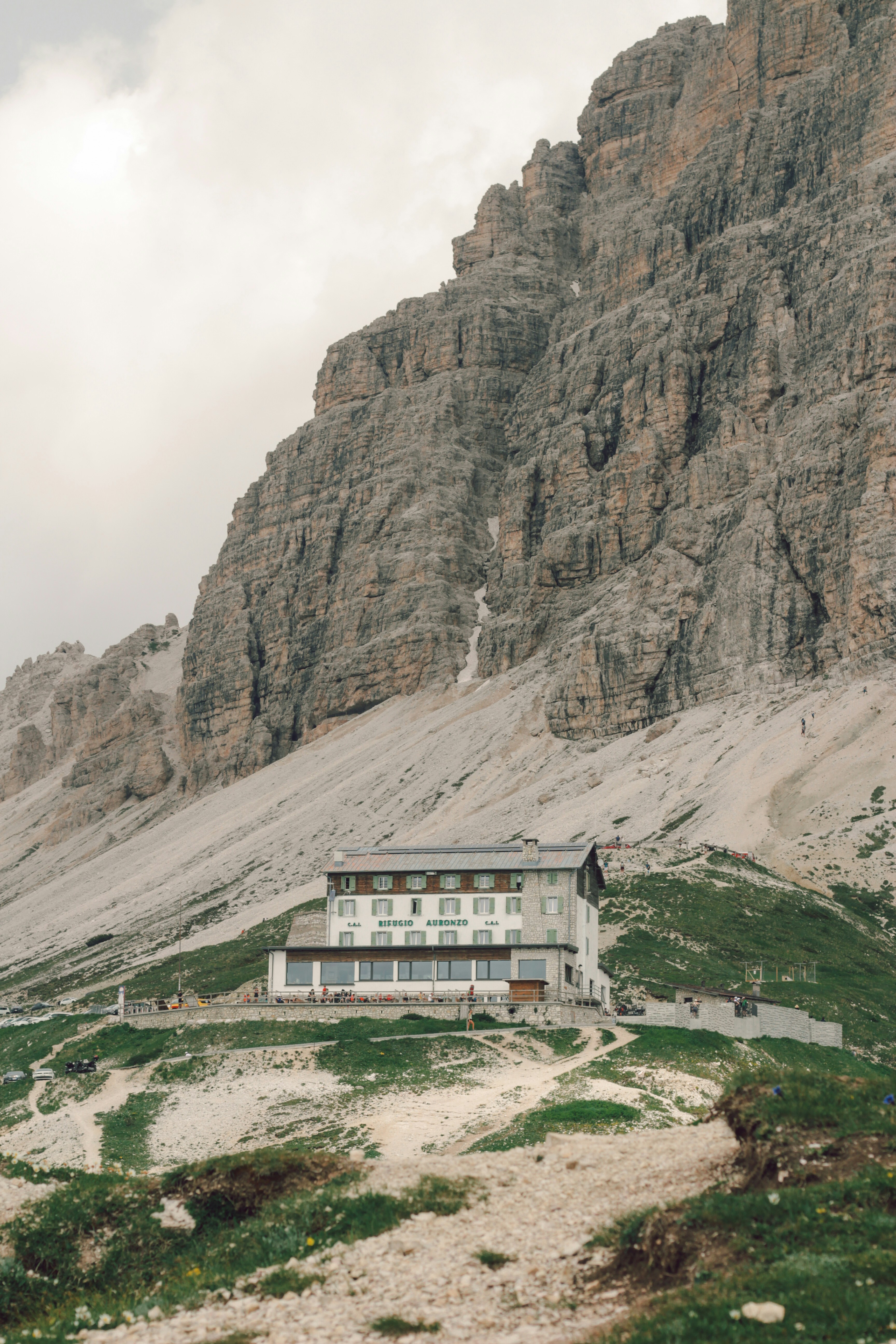 Alpine Refuge Beneath a Monolithic Cliff Face