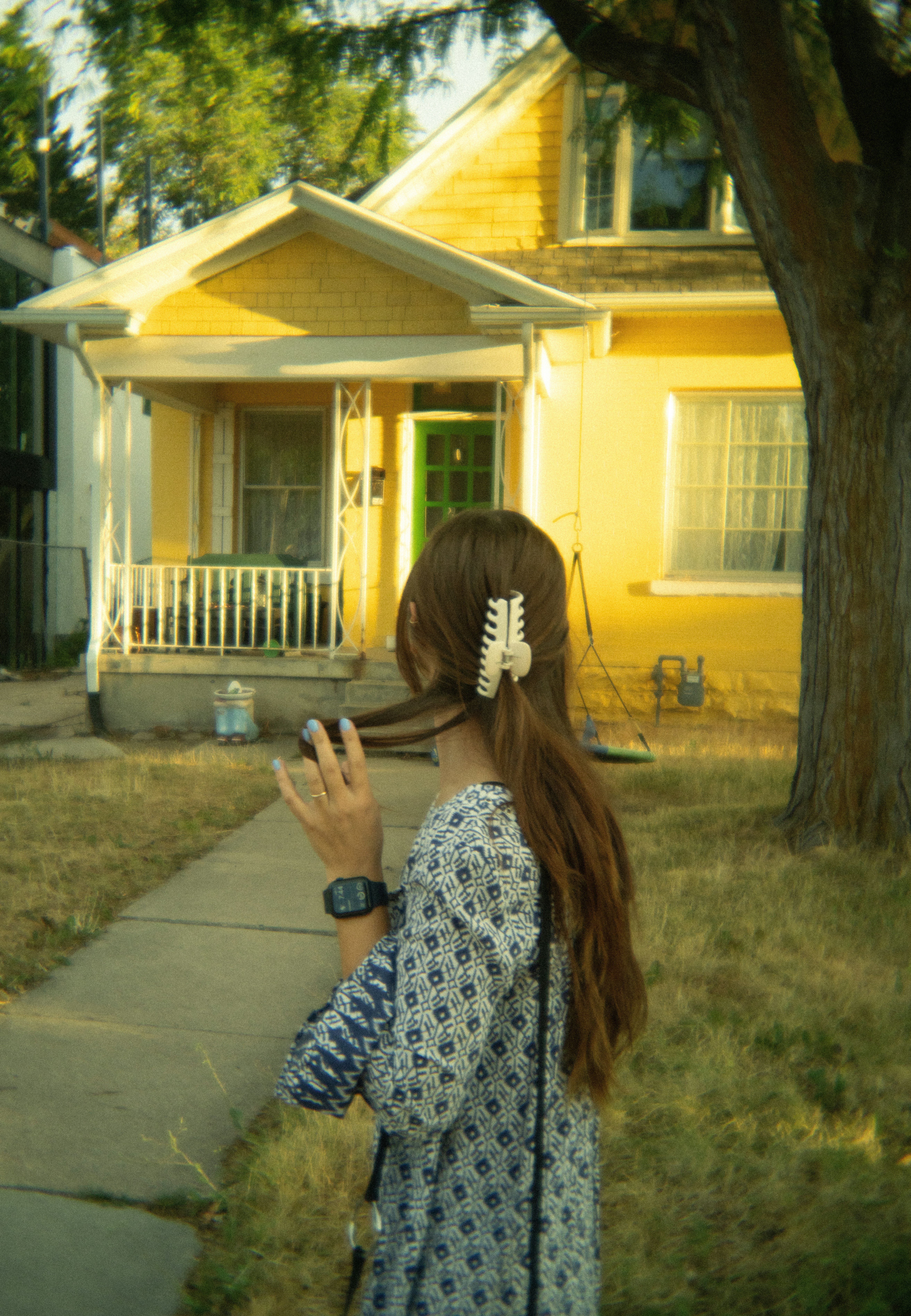 Portrait on a Sunlit Suburban Porch by a Yellow House