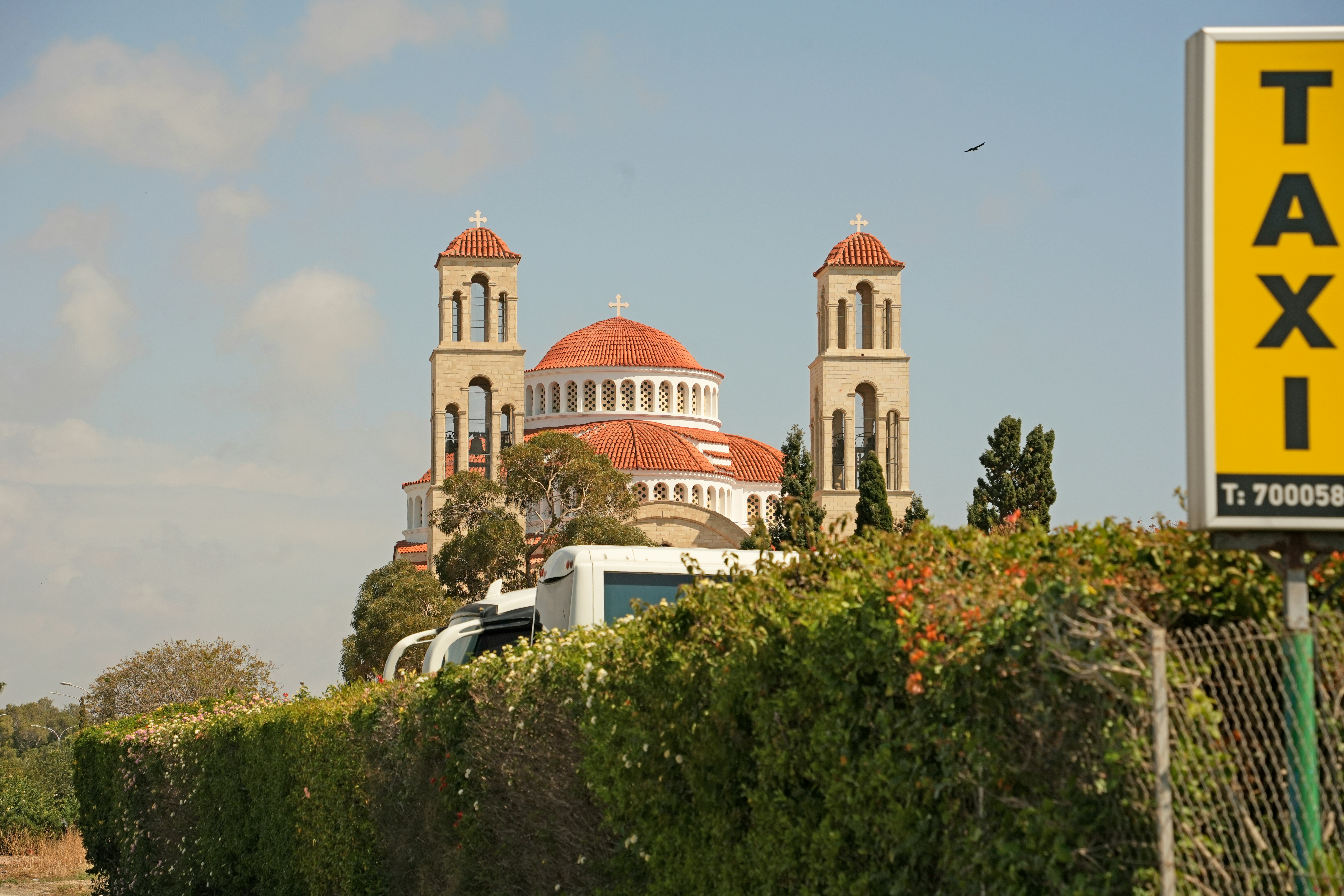 A yellow taxi sign sitting next to a lush green field photo – Free ...