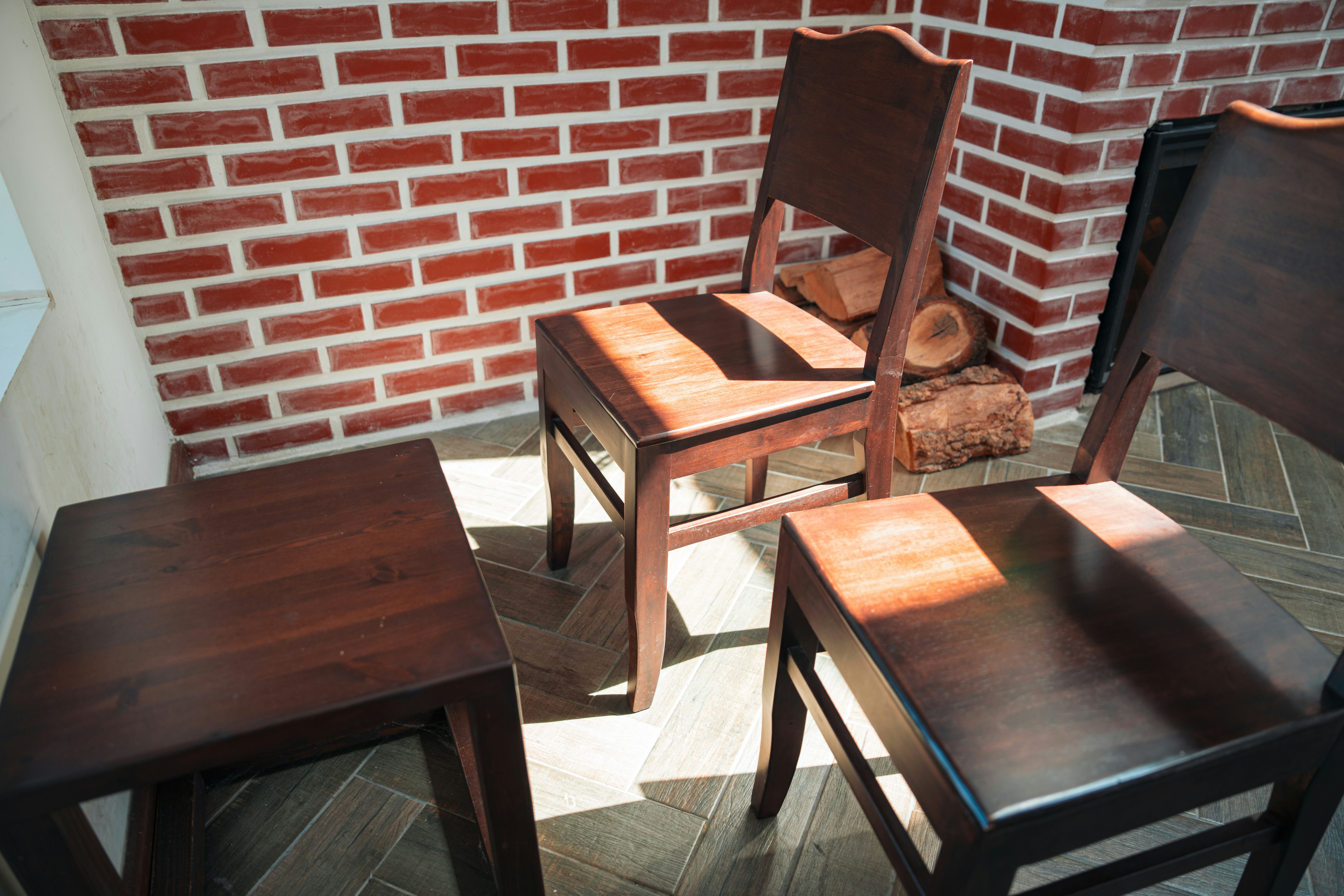 Sunlit patio chairs around a brick-walled corner