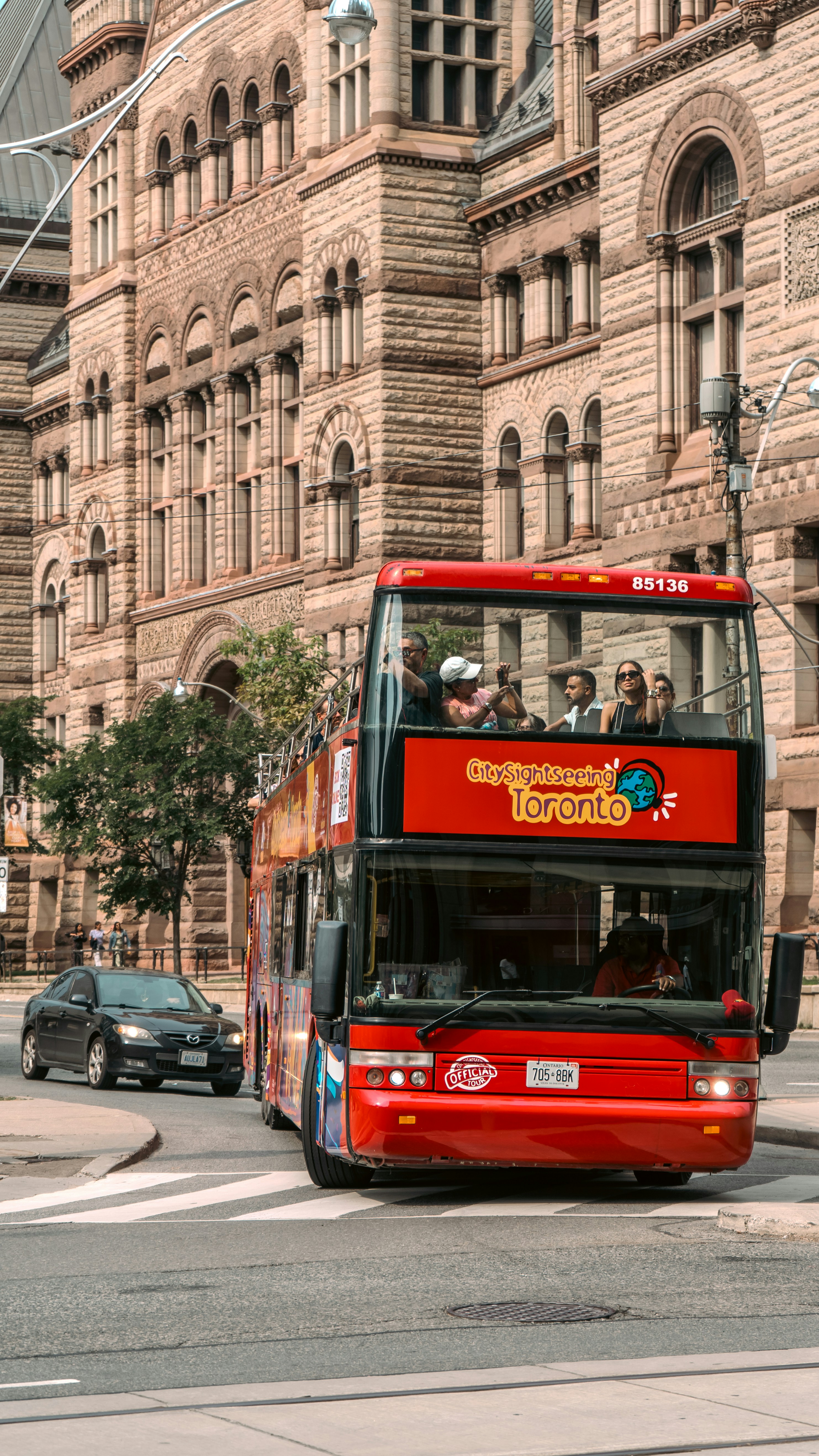 Bold Red Double-Decker Rounds a Historic Toronto Street