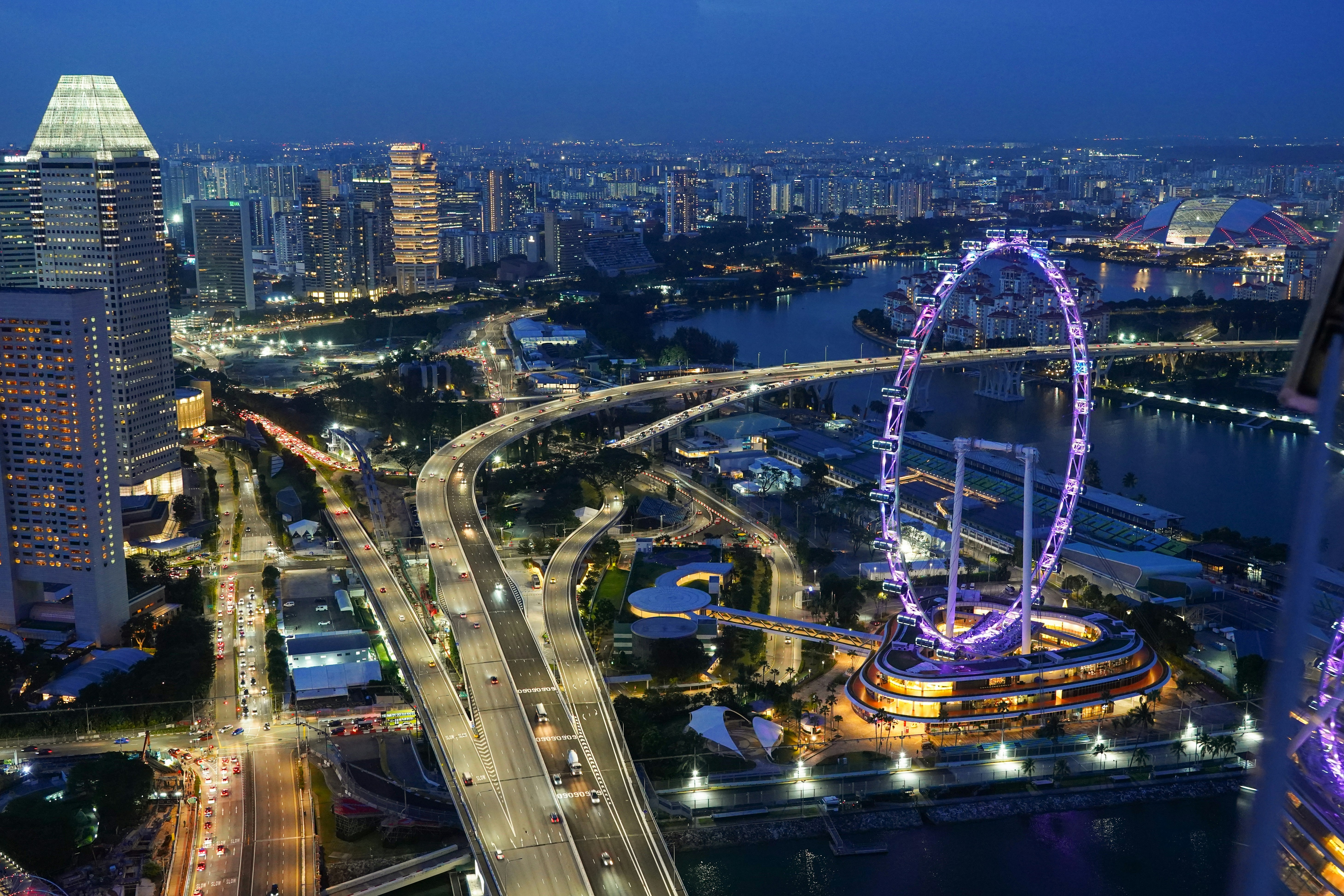 This photo, taken from the observation deck at the top of Marina Bay Sands in Singapore, captures a stunning panoramic view of the city's skyline. From here, you can see iconic landmarks like the ArtScience Museum and Supertree Grove in Gardens by the Bay. The skyscrapers of the Central Business District rise in the distance, underscoring Singapore’s role as a global financial hub. The Marina Bay Sands observation deck offers an unmatched view of this vibrant city.