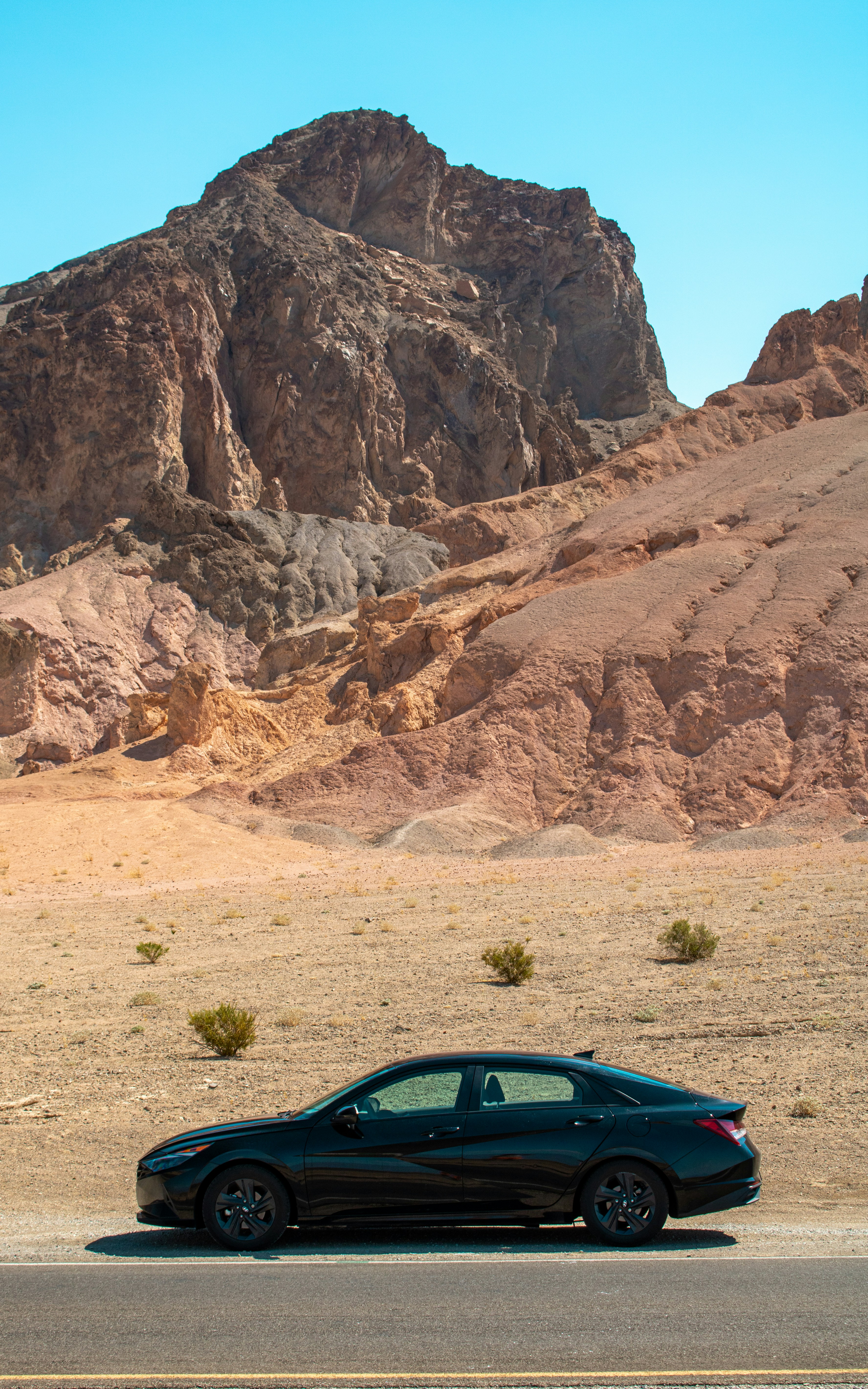 Sable Coupe on the Desert Spine: Roadside Stillness Beneath Red Rock Cliffs